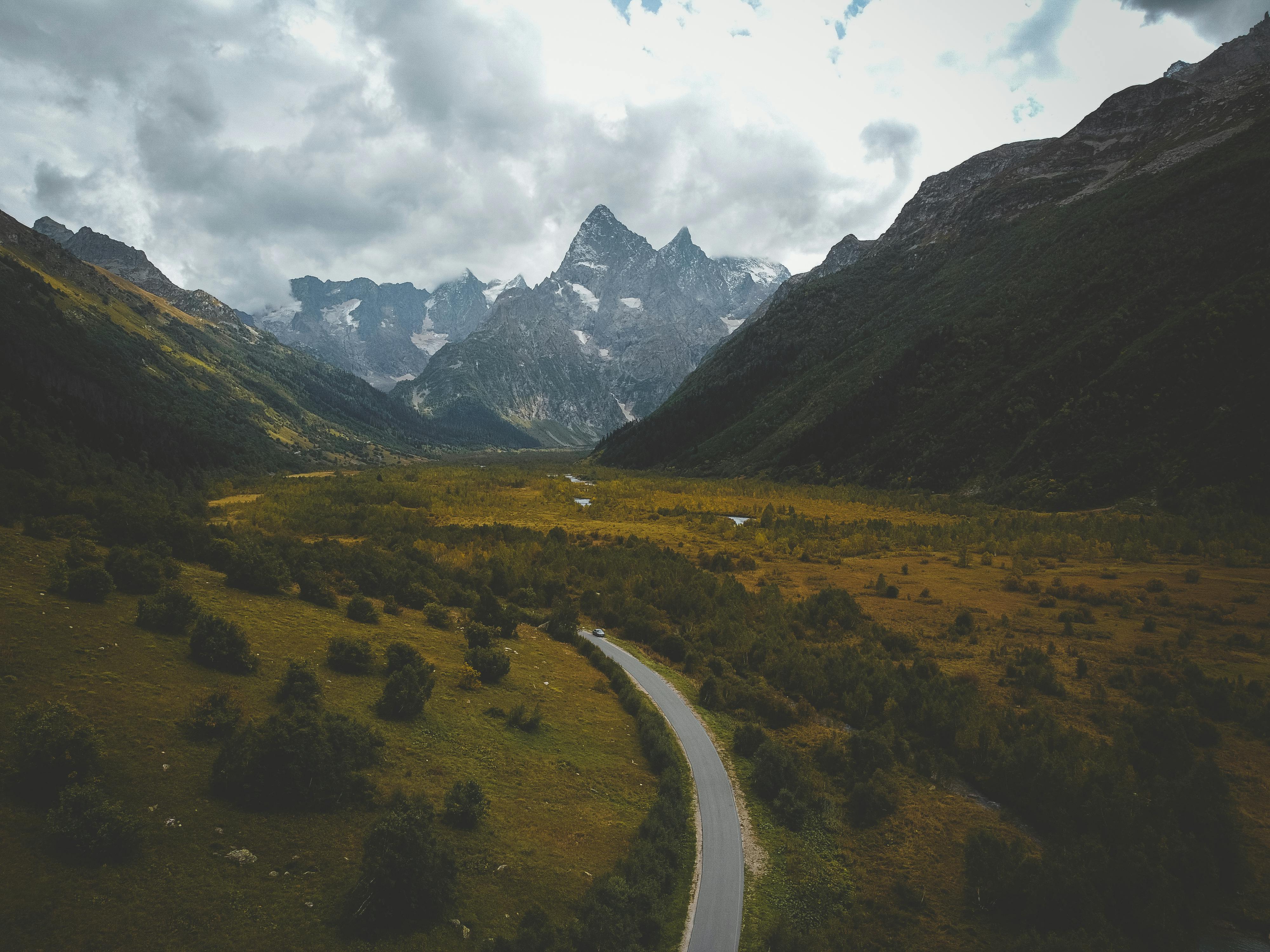 A Road Between Green Mountains · Free Stock Photo
