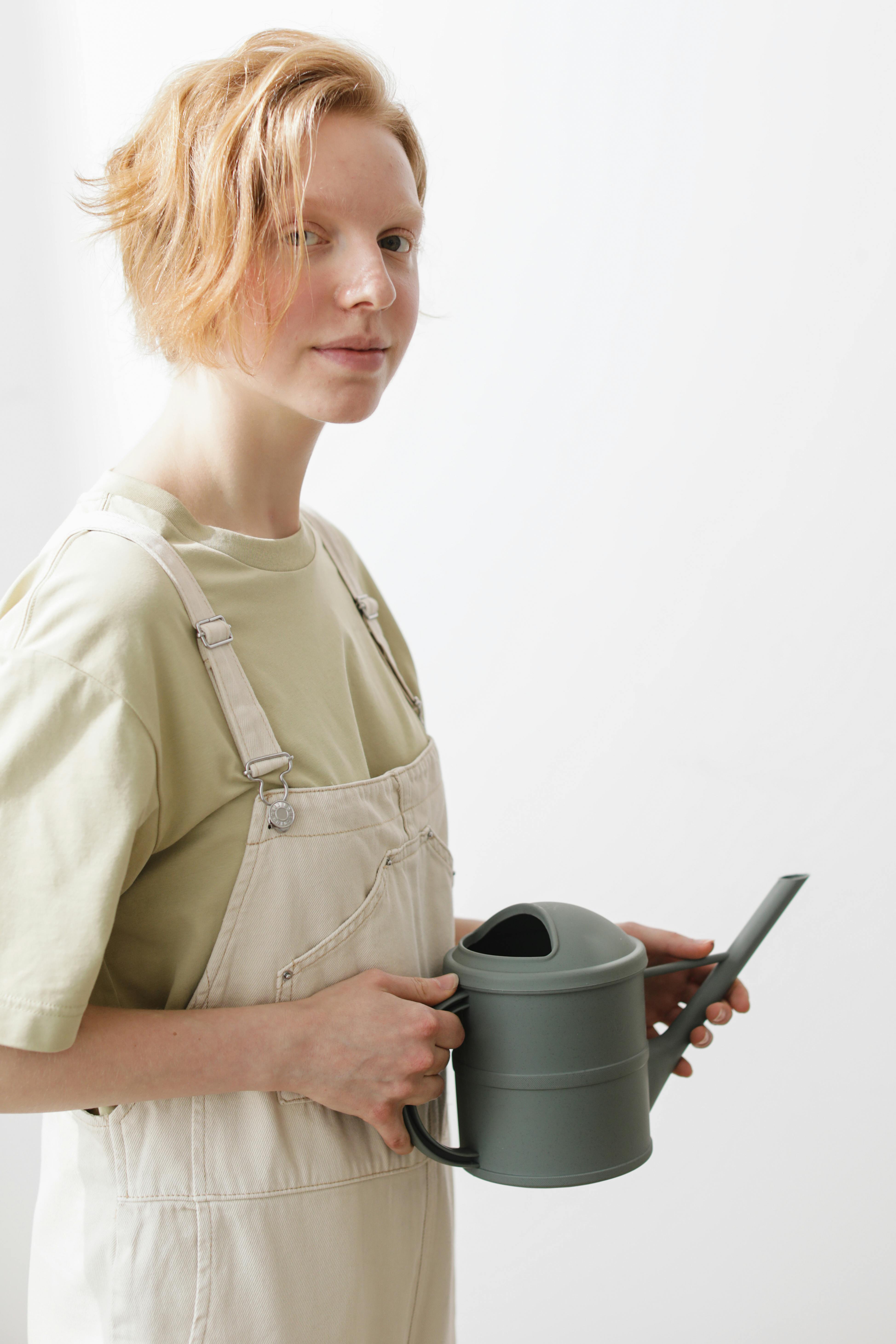 A Woman Holding Watering Can Smiling at Camera · Free Stock Photo