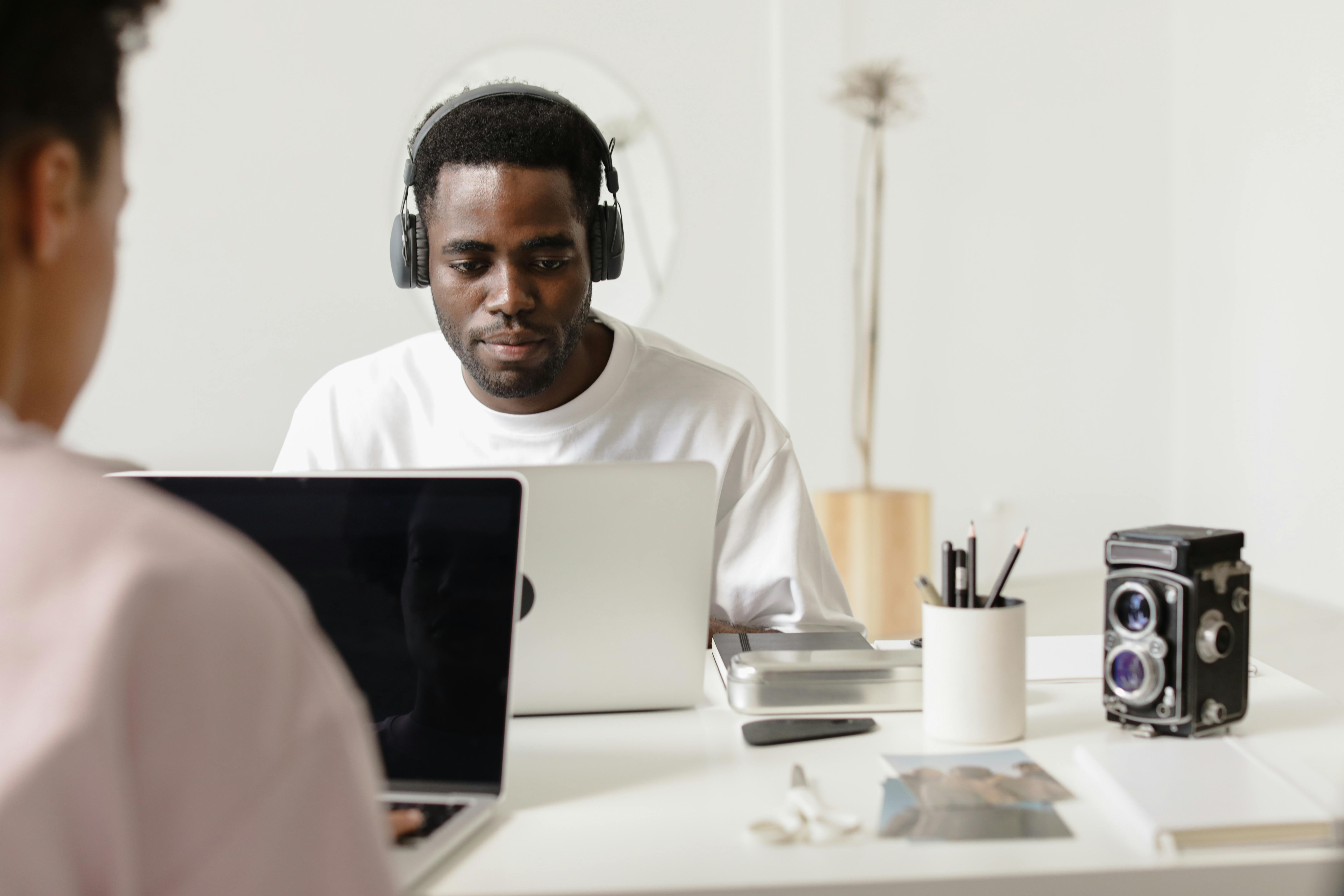 Man Wearing Headphones While Using His Laptop · Free Stock Photo