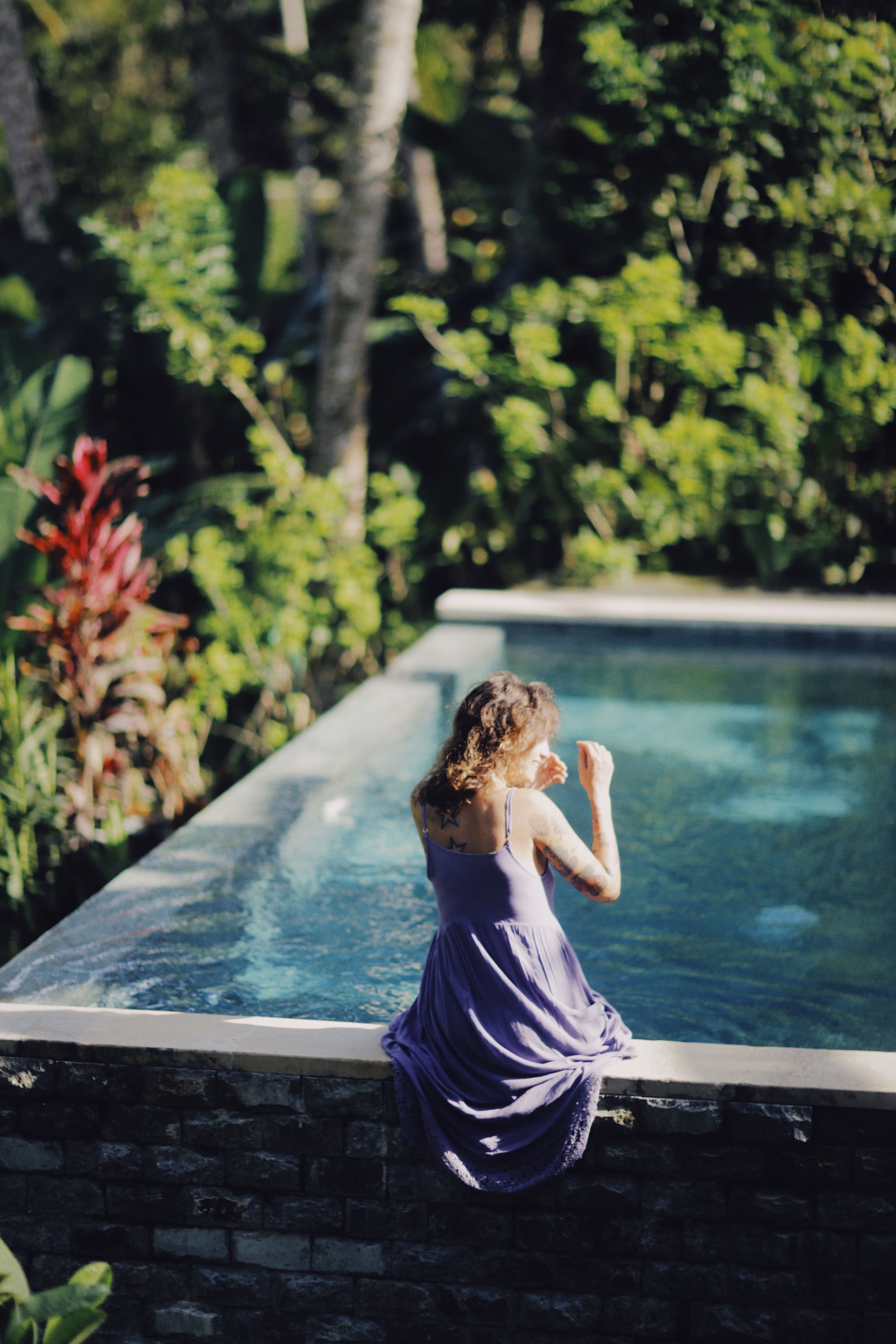 Woman Sitting on Swimming Pools Edge · Free Stock Photo