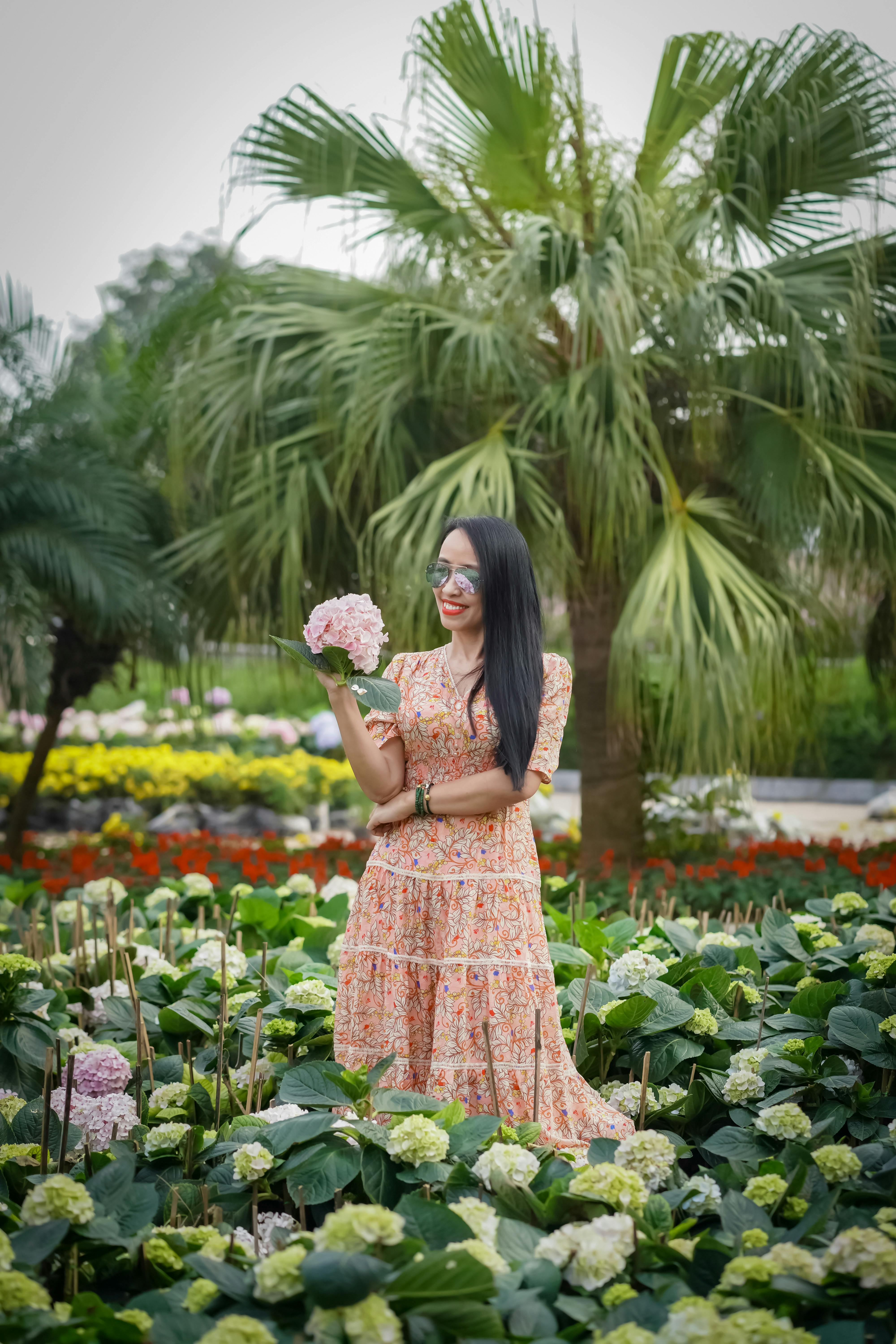 Woman in Floral Dress Looking the Bunch of Flowers She is Holding ...
