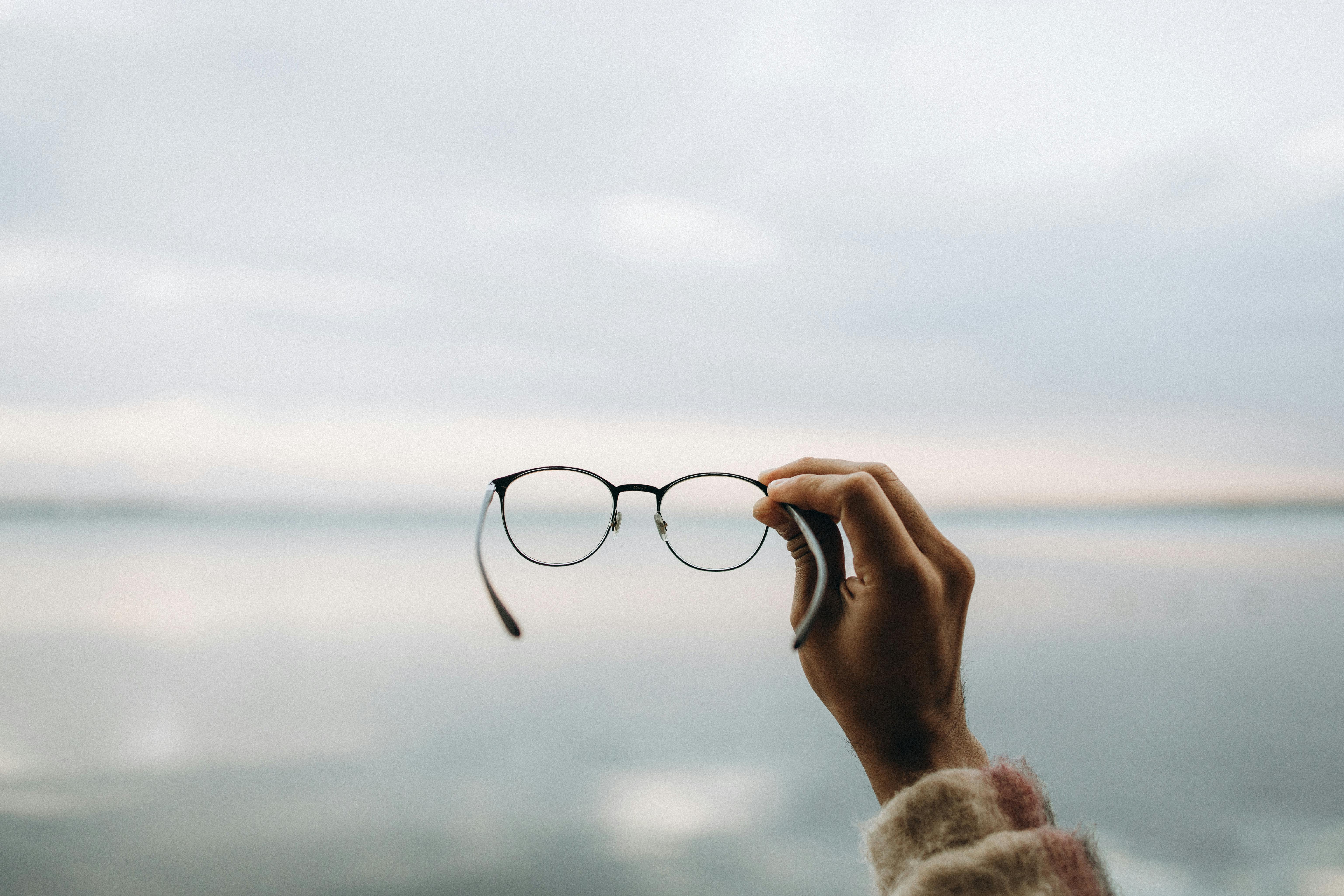 Person Holding Black Framed Eyeglasses · Free Stock Photo