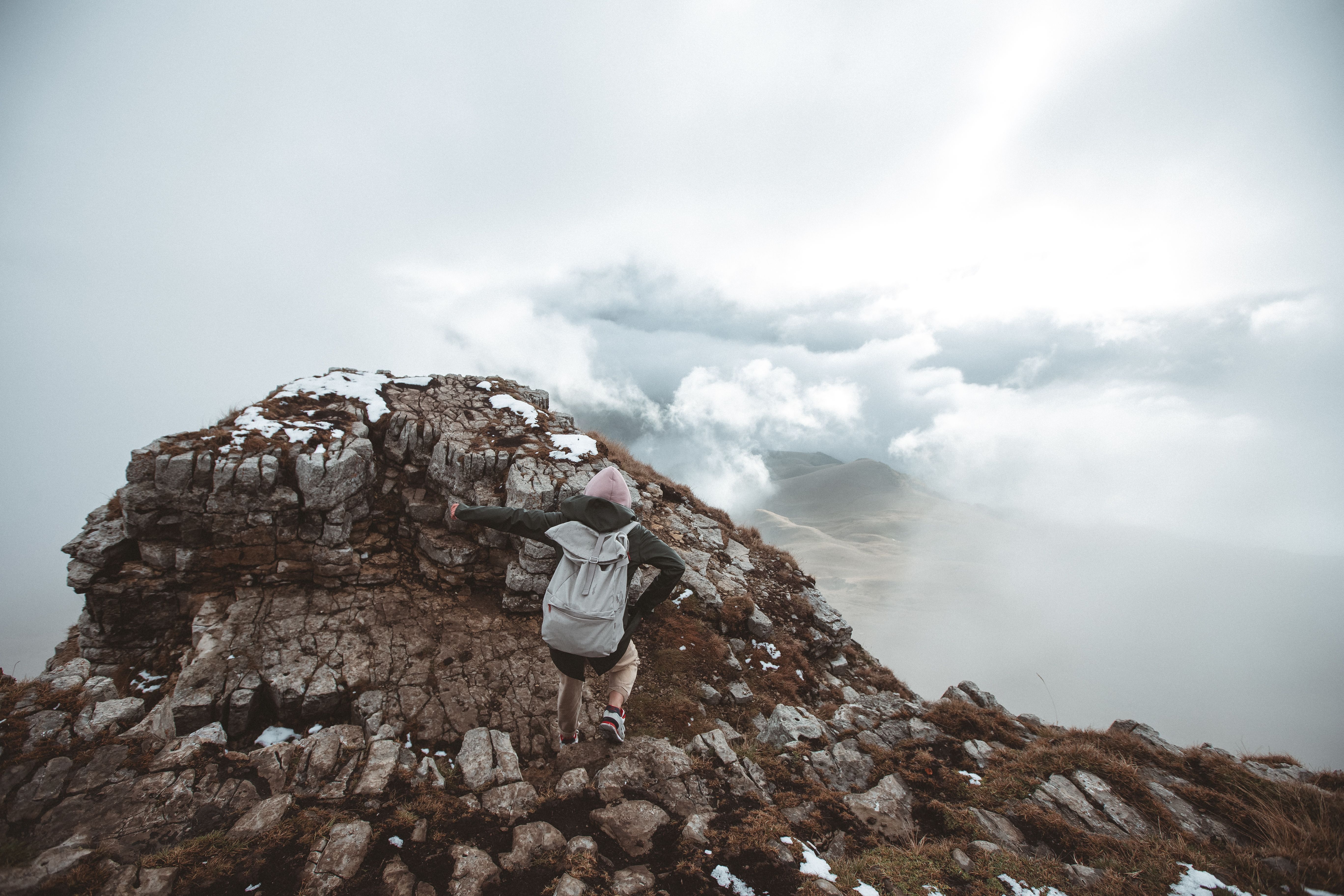 A Back View of A Person Climbing a A Mountain Peak around Clouds Fog ...