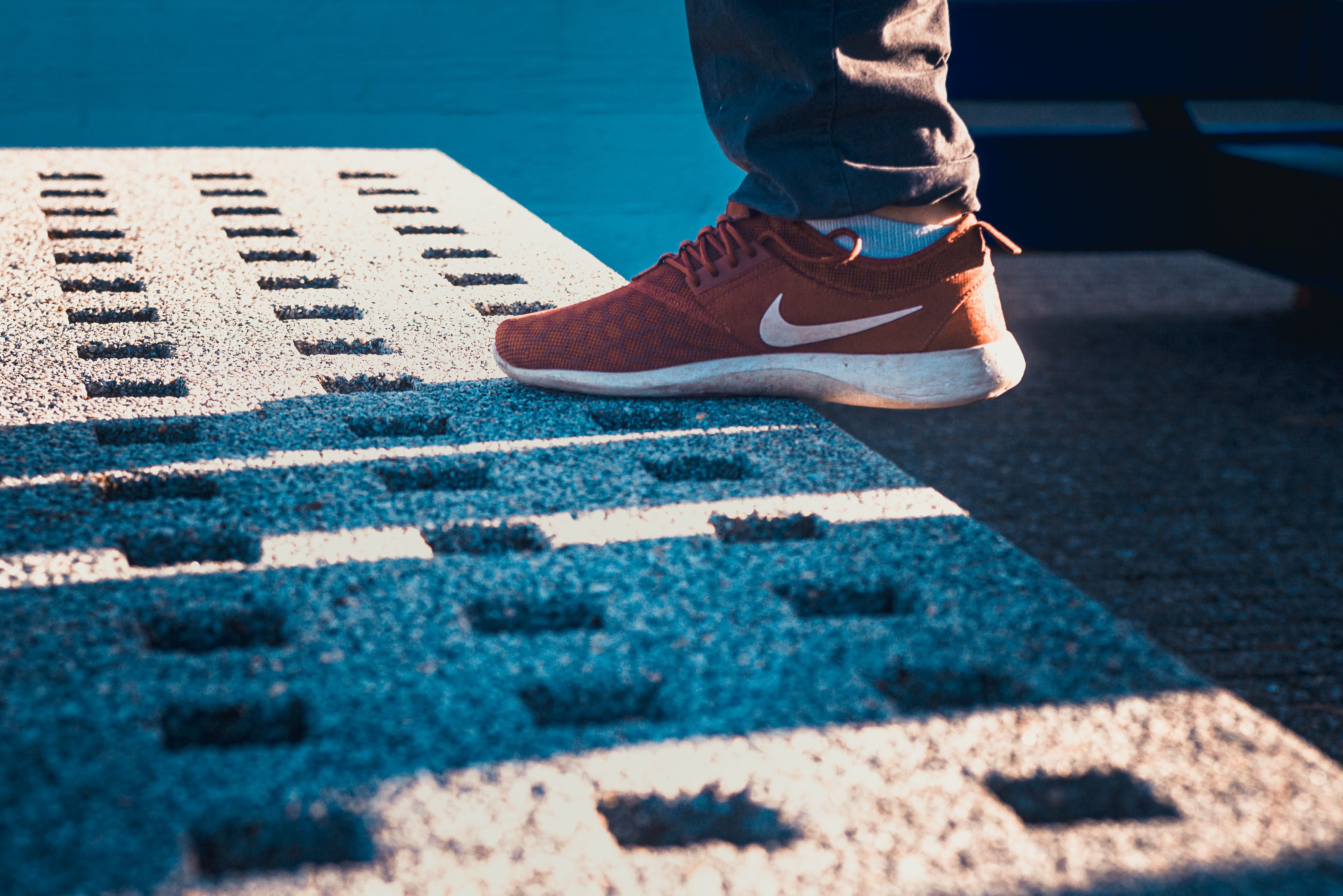 Closeup of a Mans Foot in a Trainer Shoe Stepping on a Concrete Block ...