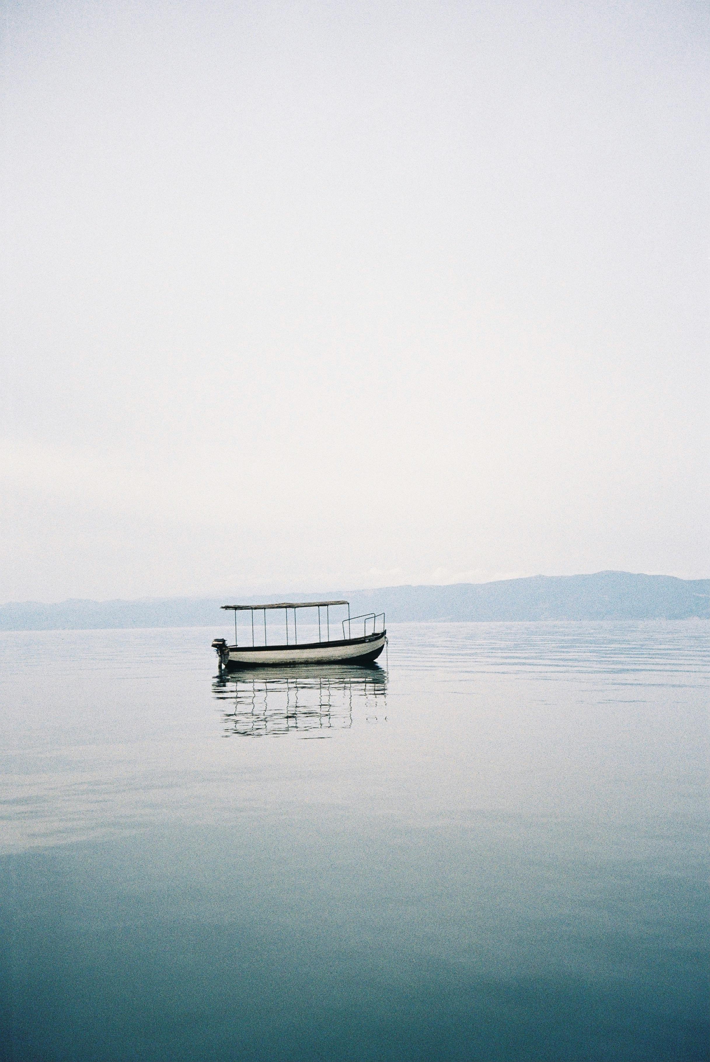 Clear Sky over Small Empty Boat on Lake · Free Stock Photo