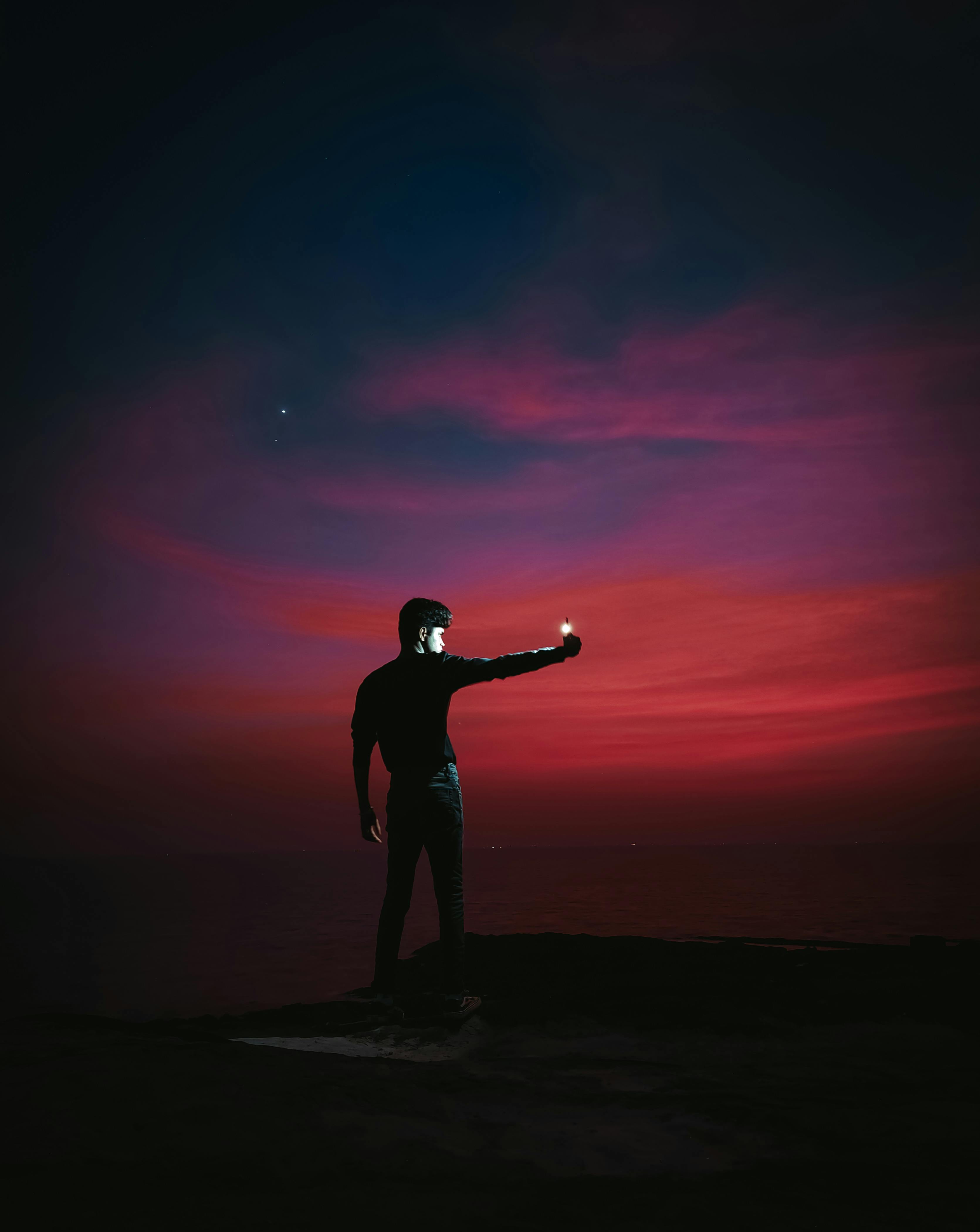 Man Holding Light at Dusk · Free Stock Photo