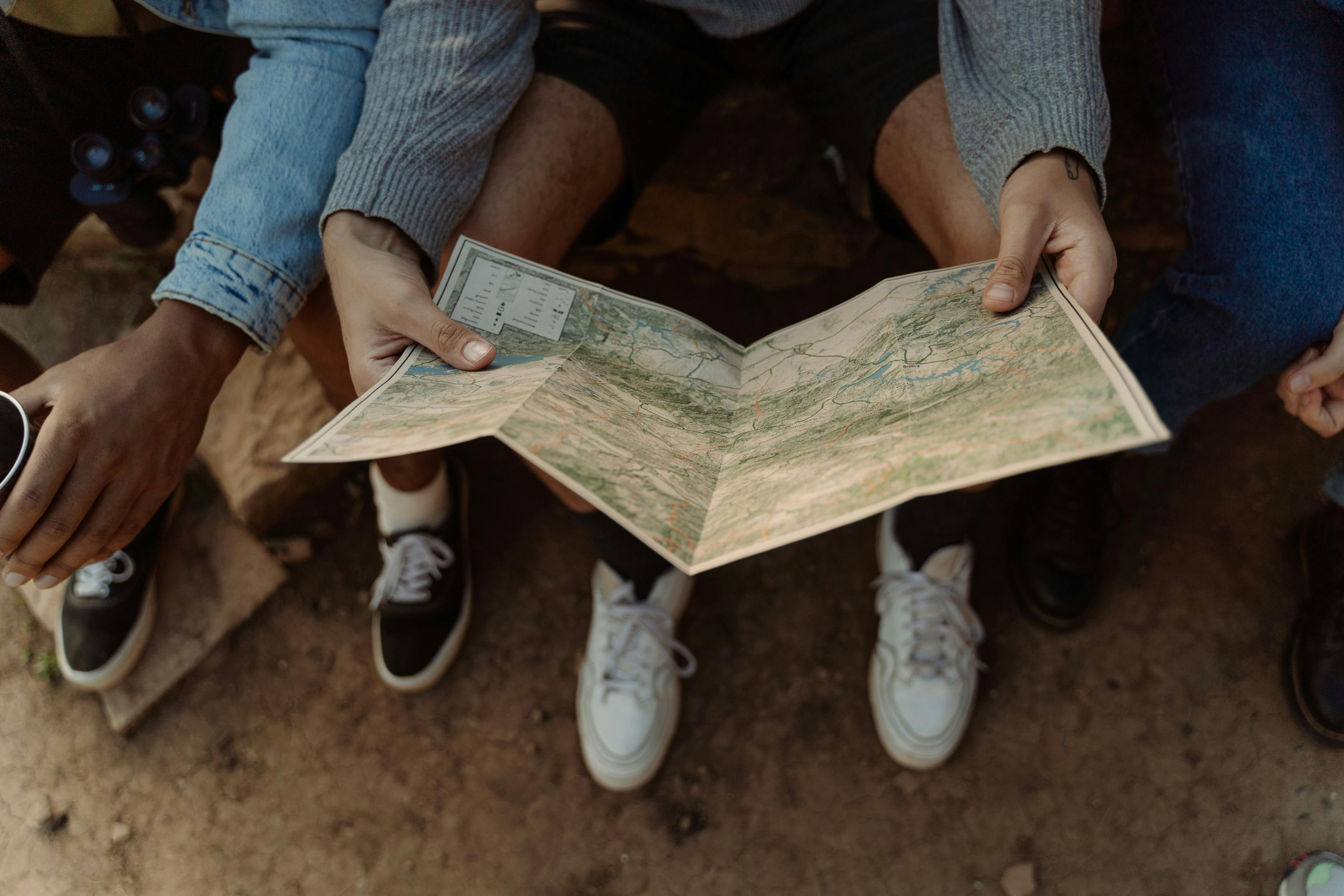 Map in Hands of Sitting Tourist · Free Stock Photo