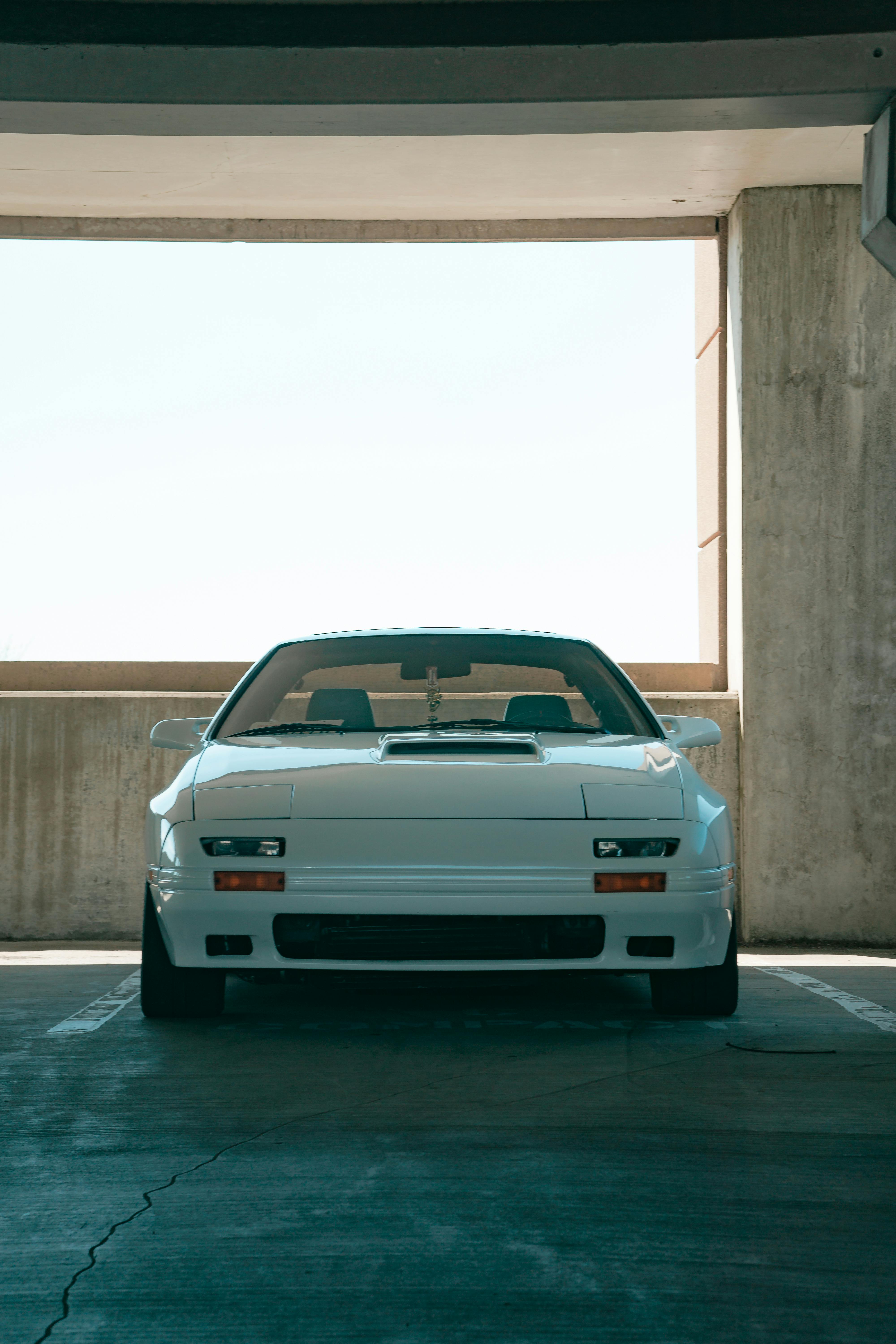 Front View of White Car Parked in Empty Parking Lot · Free Stock Photo
