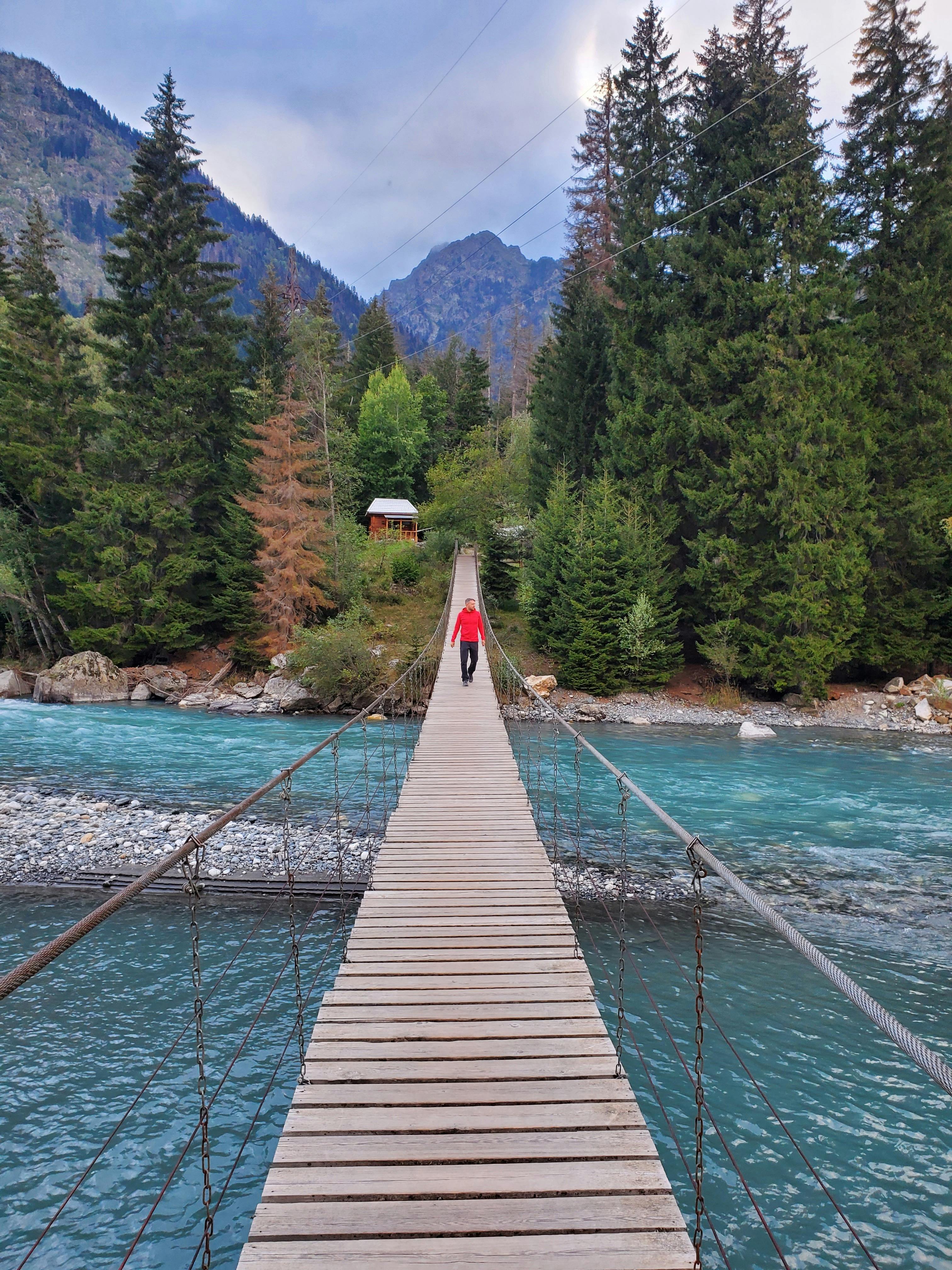 Man in Red Jacket Standing on Wooden Bridge · Free Stock Photo
