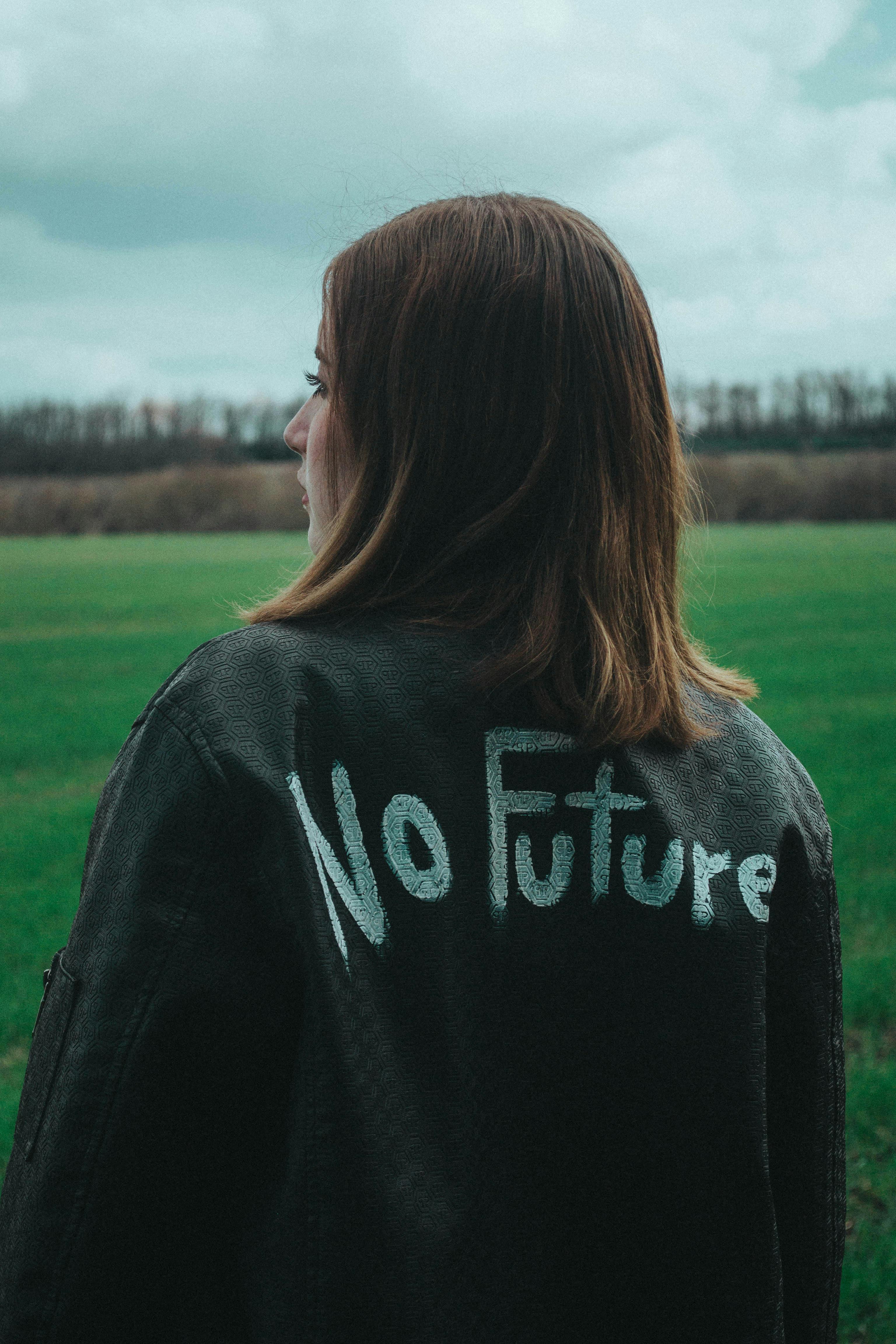 Woman in Black Coat with Statement Painted on Back · Free Stock Photo