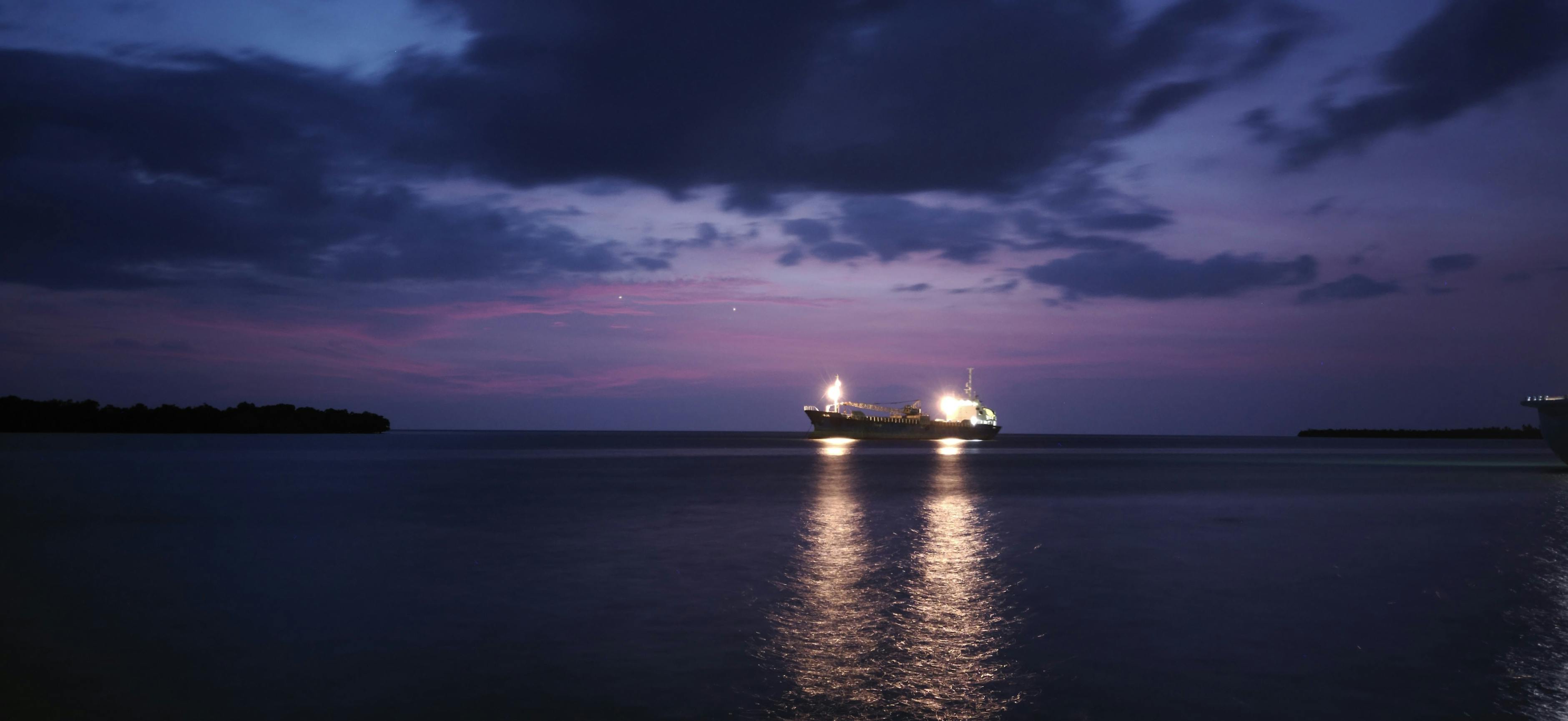 Photograph of a Vessel on the Sea During Dusk Time · Free Stock Photo
