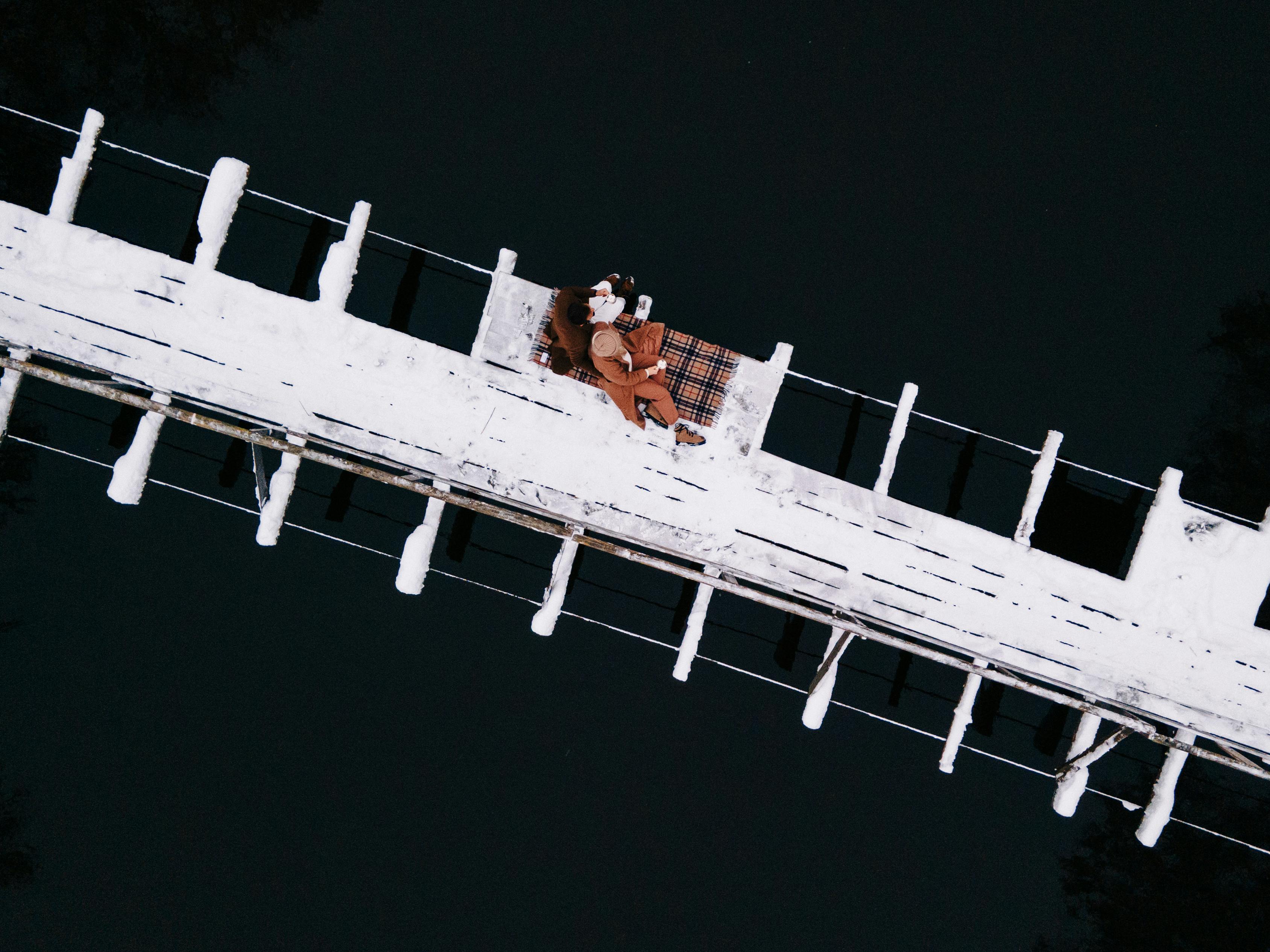 A Couple Sitting on the Bridge · Free Stock Photo