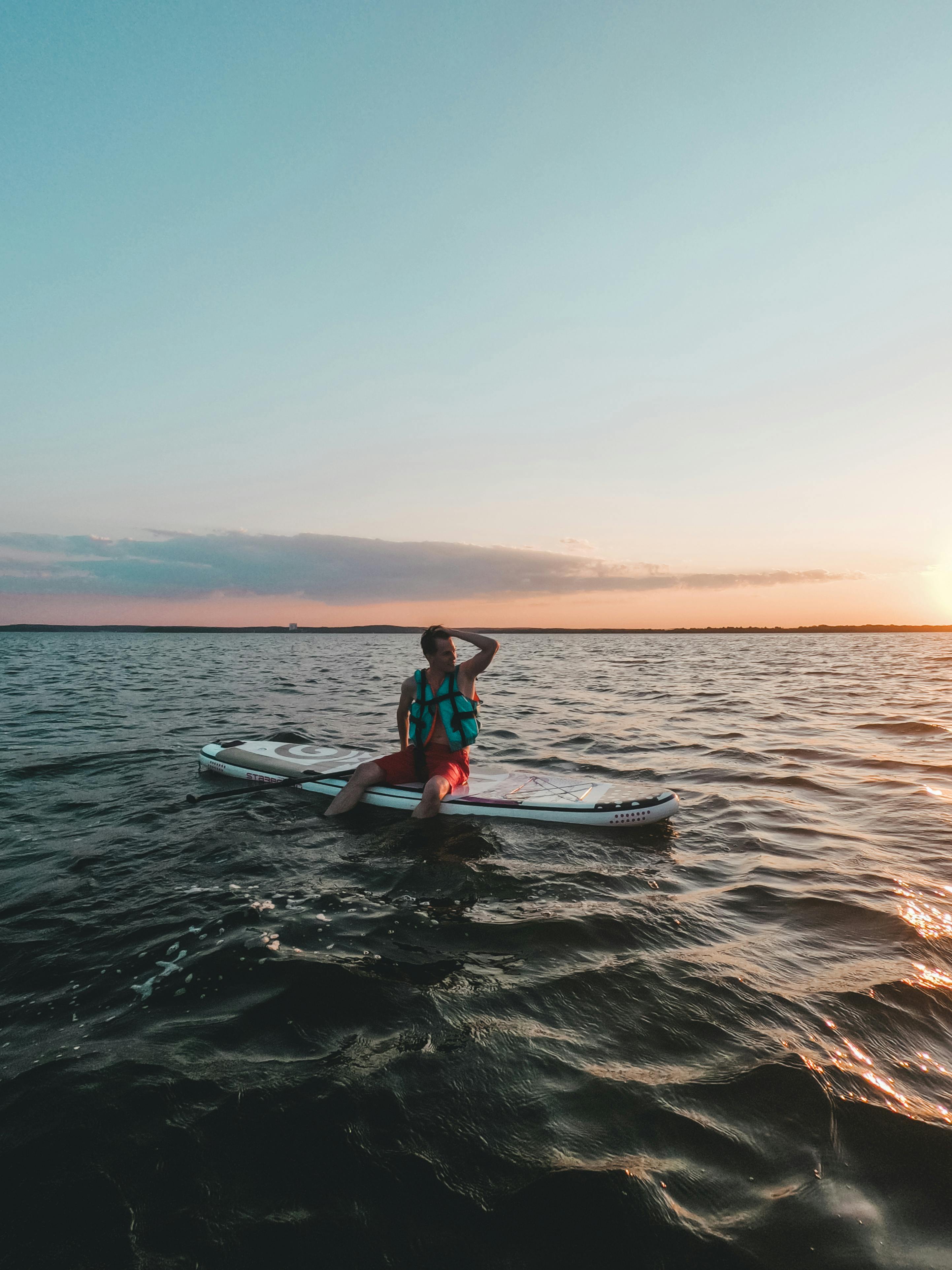 A Man Sitting on a Paddleboard · Free Stock Photo