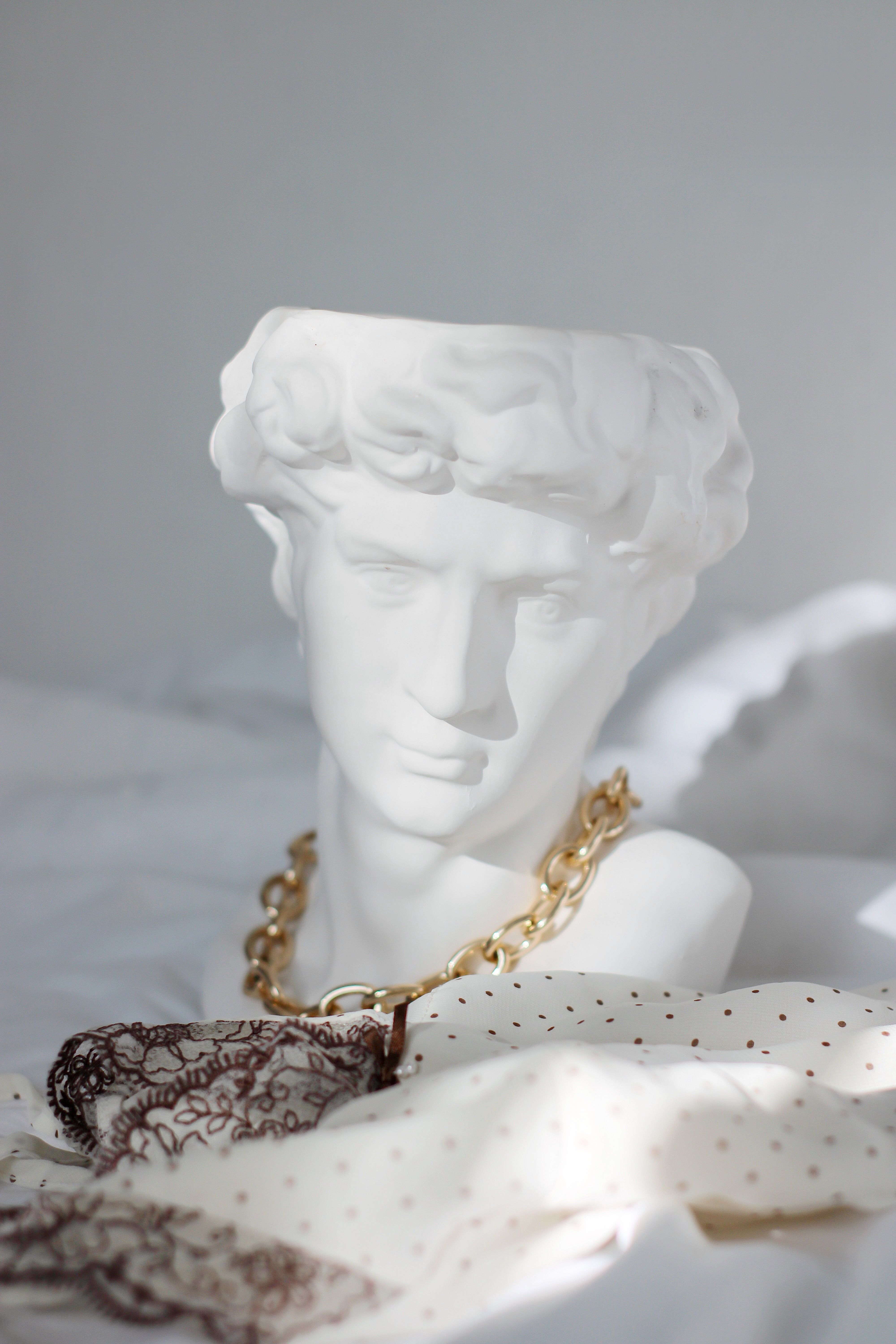 A Head of a Statue Wearing Gold Necklaces · Free Stock Photo