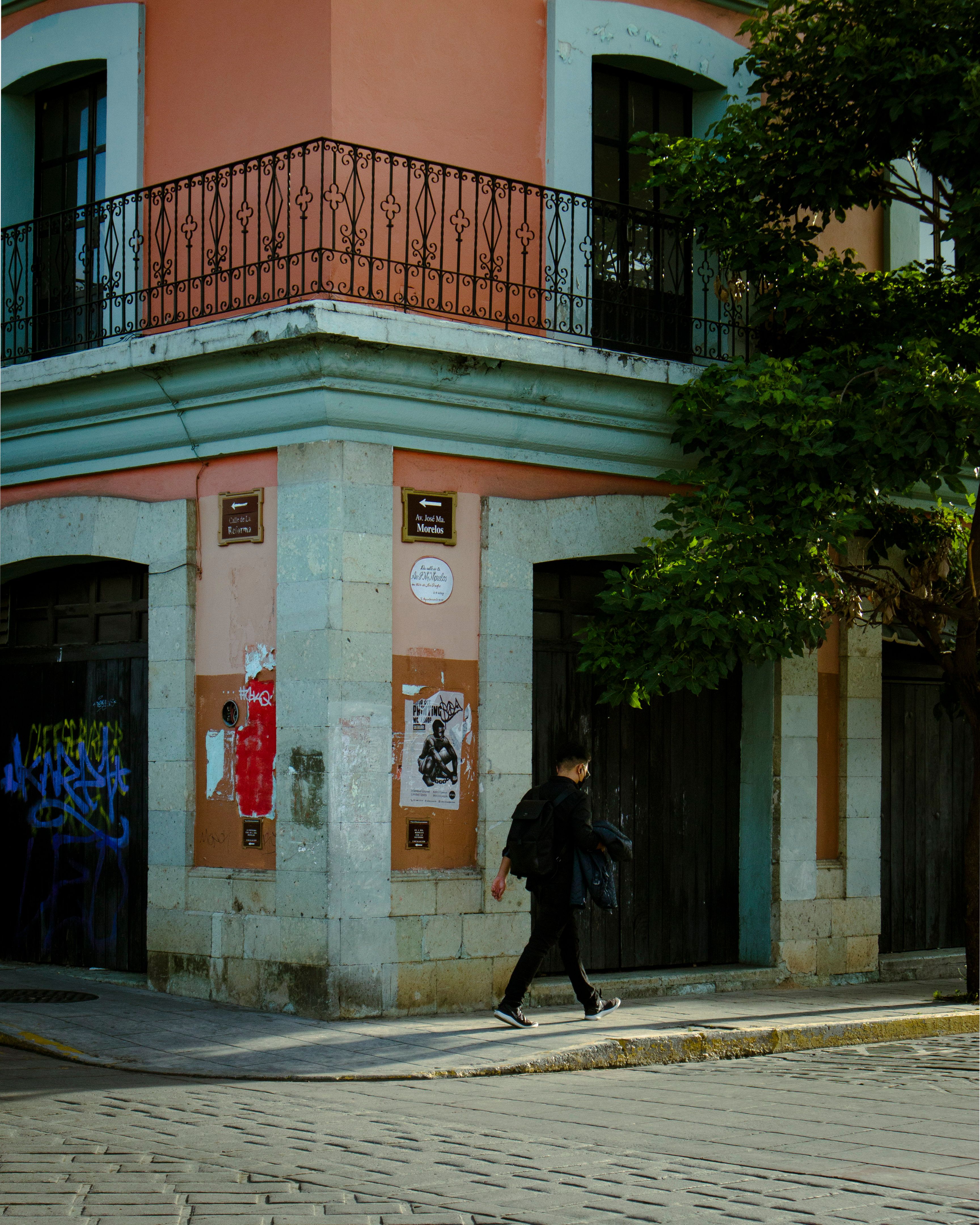 Man Walking Beside a Restaurant Building · Free Stock Photo