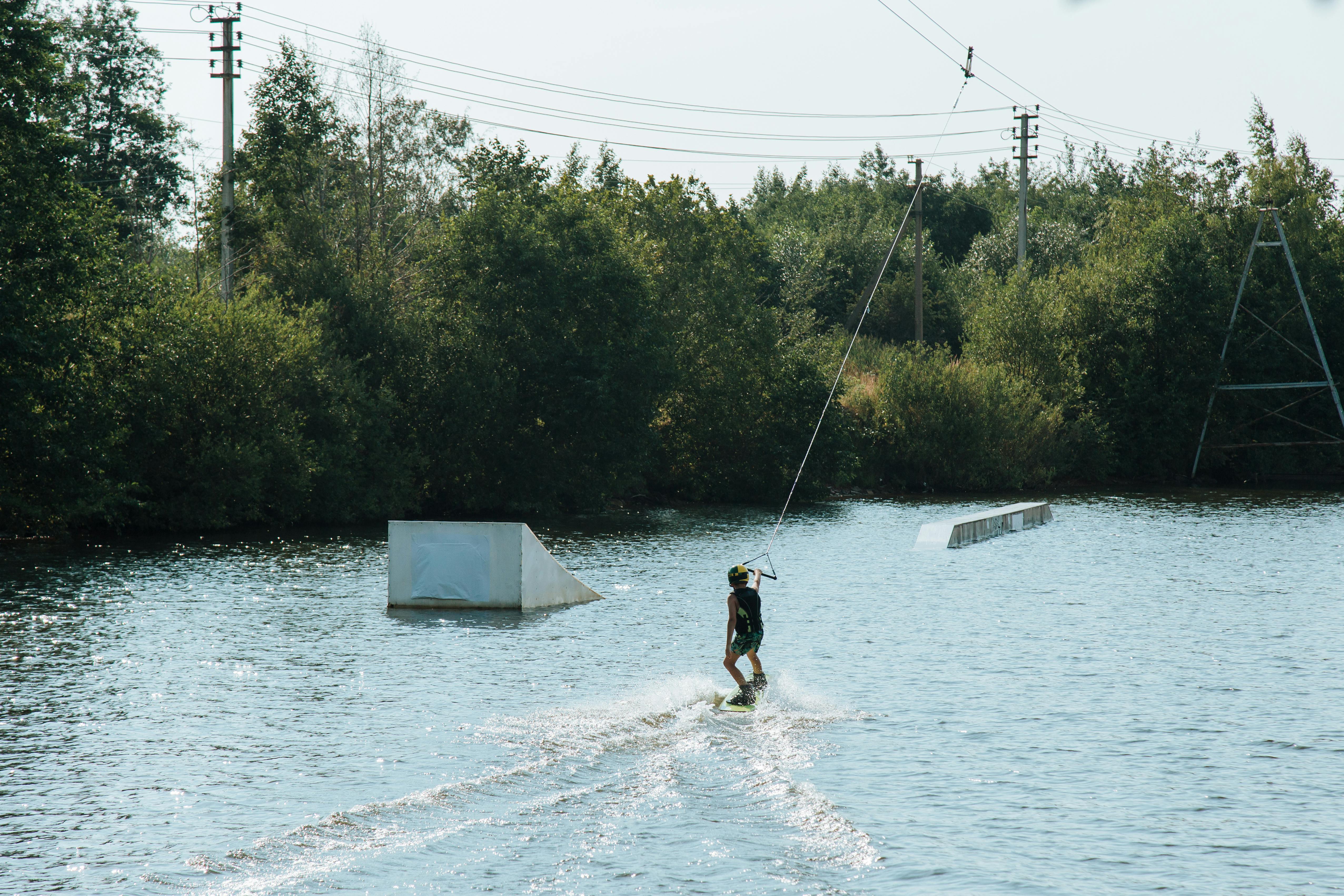 Woman Wakeboarding near Ramp on Lake · Free Stock Photo