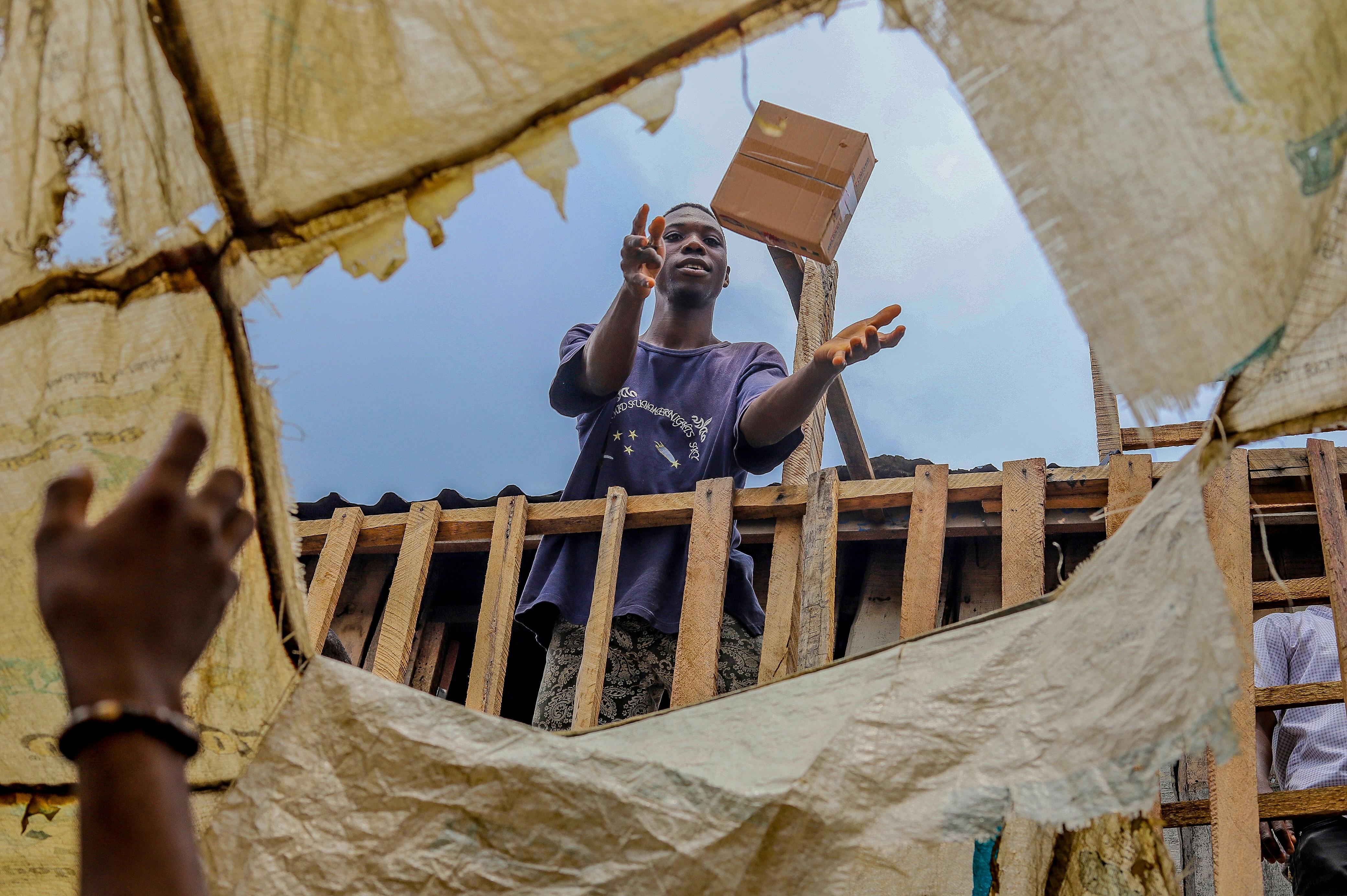A Man in Purple Shirt Throwing a Cardboard Box · Free Stock Photo