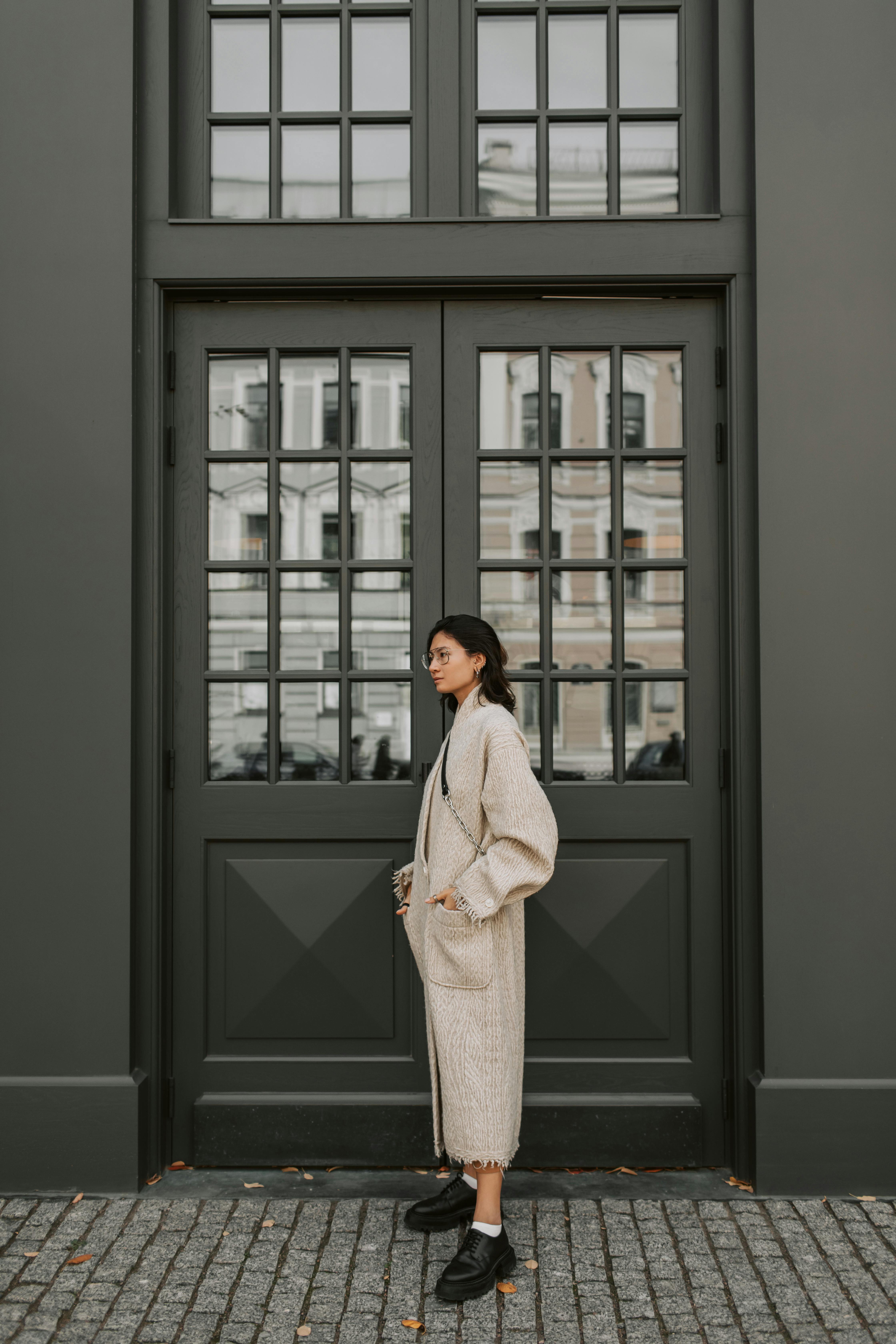 Woman in Coat standing beside a Double Doors · Free Stock Photo