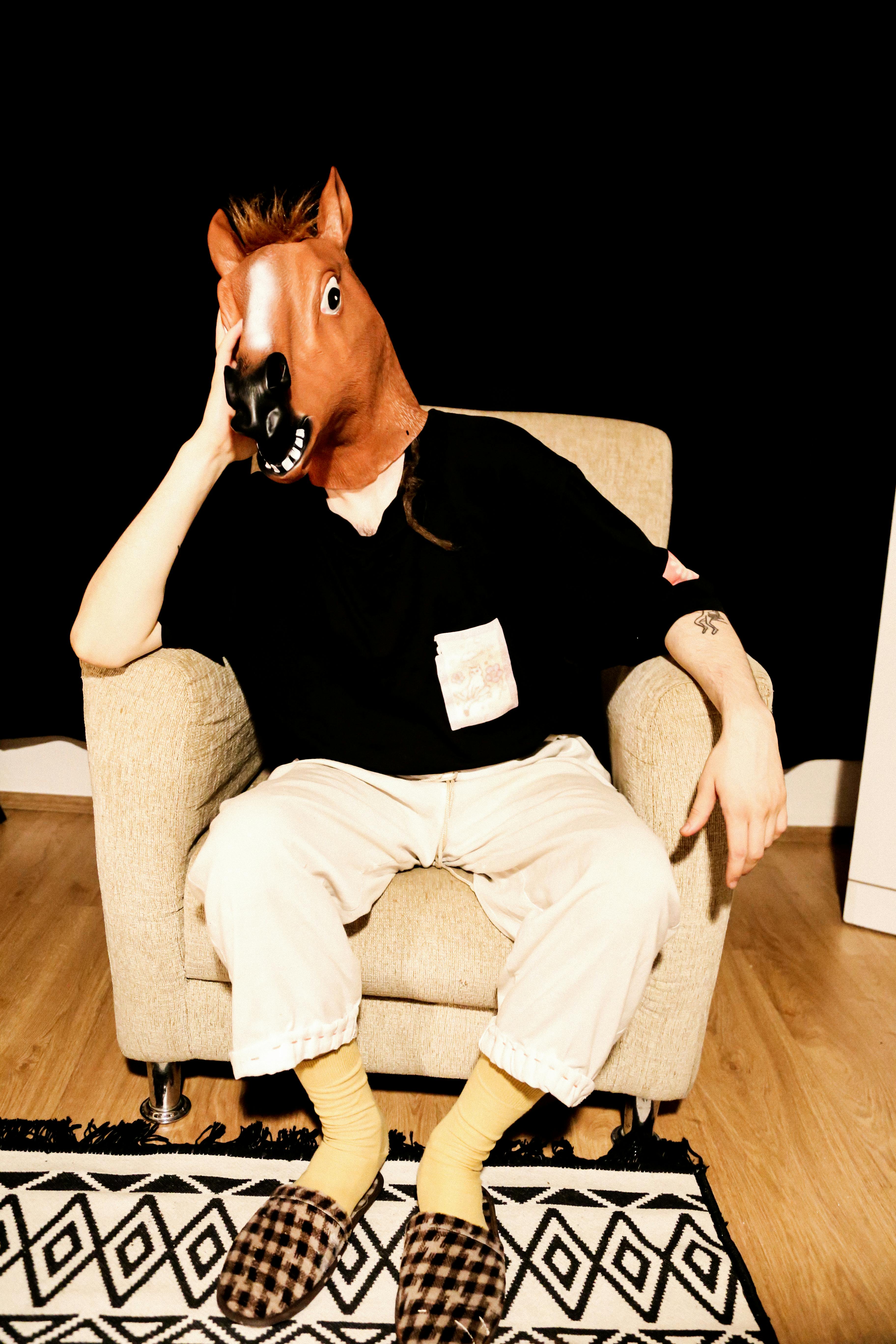 Person with a Mask Sitting on a Chair · Free Stock Photo