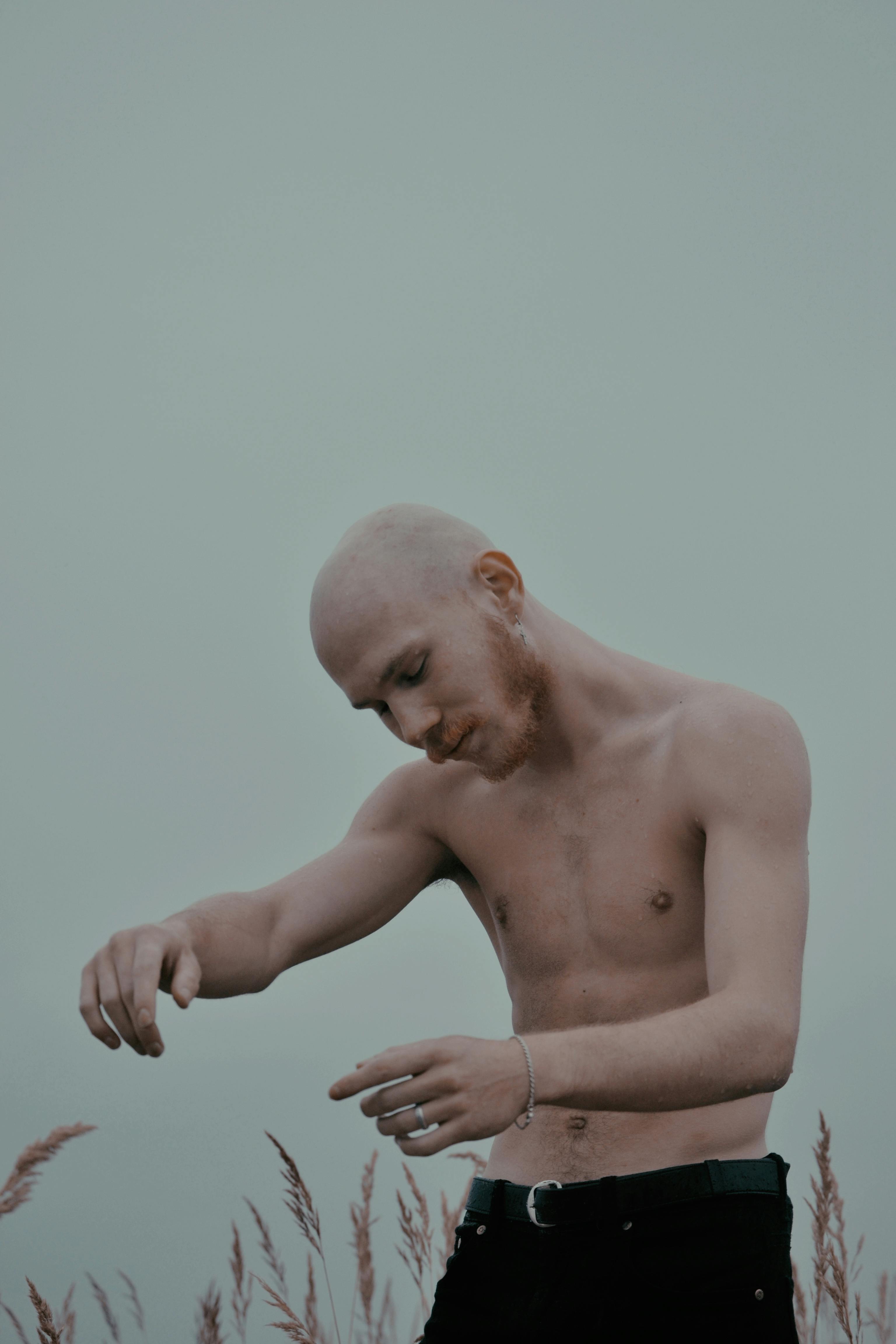 Young Bald Headed Man Standing Topless and Gesturing · Free Stock Photo