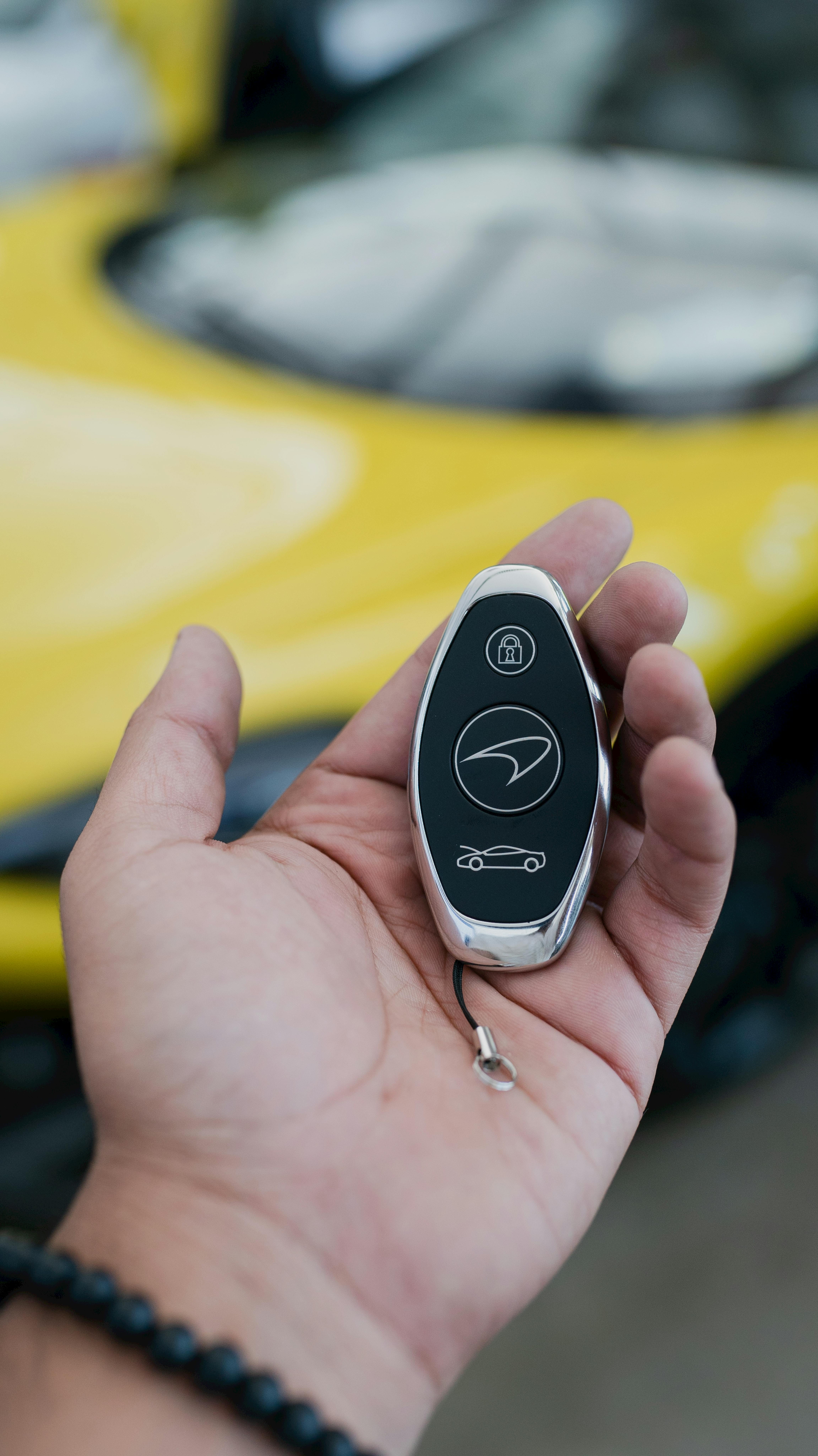 A Person Holding a Mclaren Car Key · Free Stock Photo