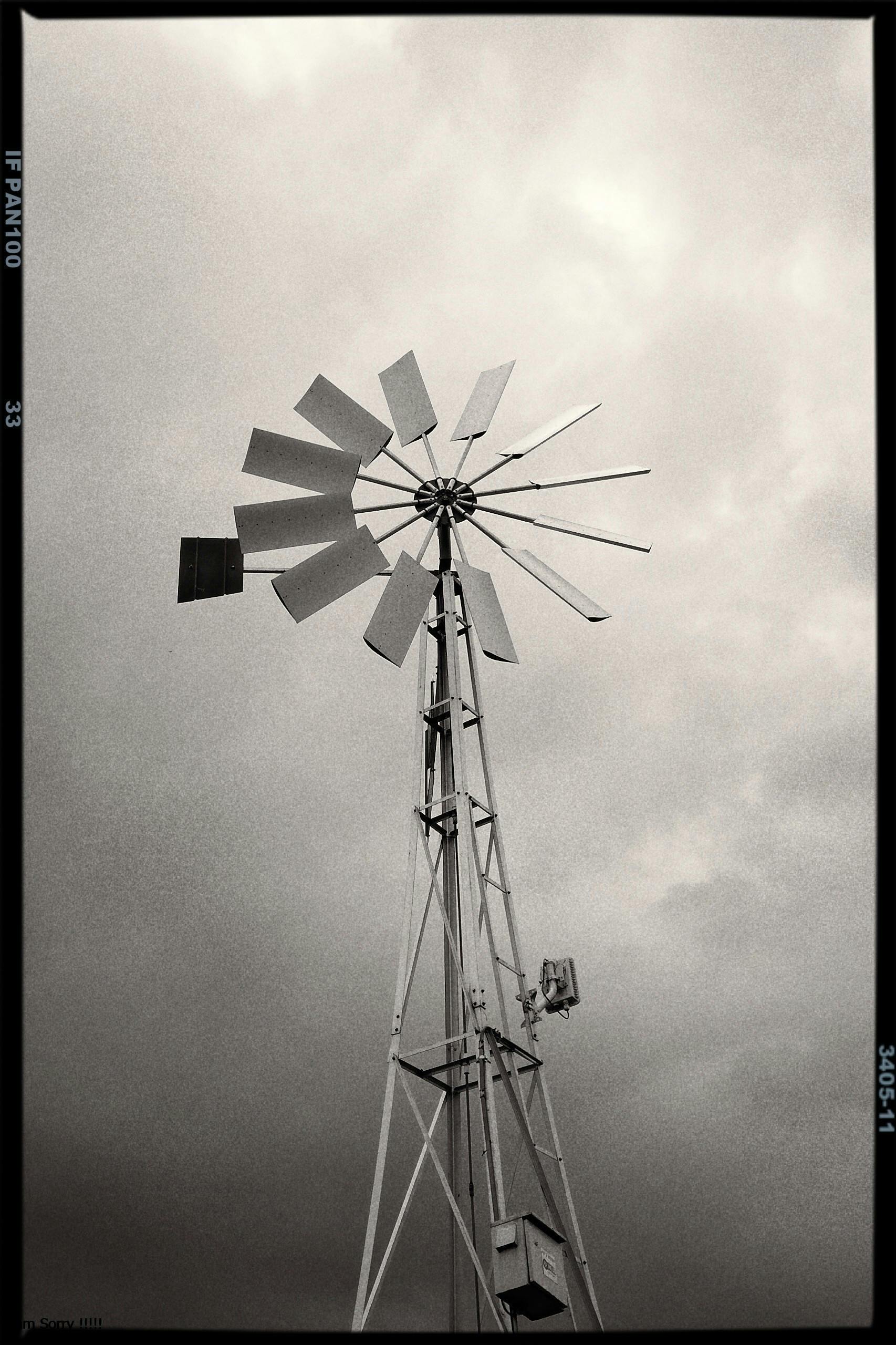 A Grayscale Photo of a Windmill Under a Cloudy Sky · Free Stock Photo