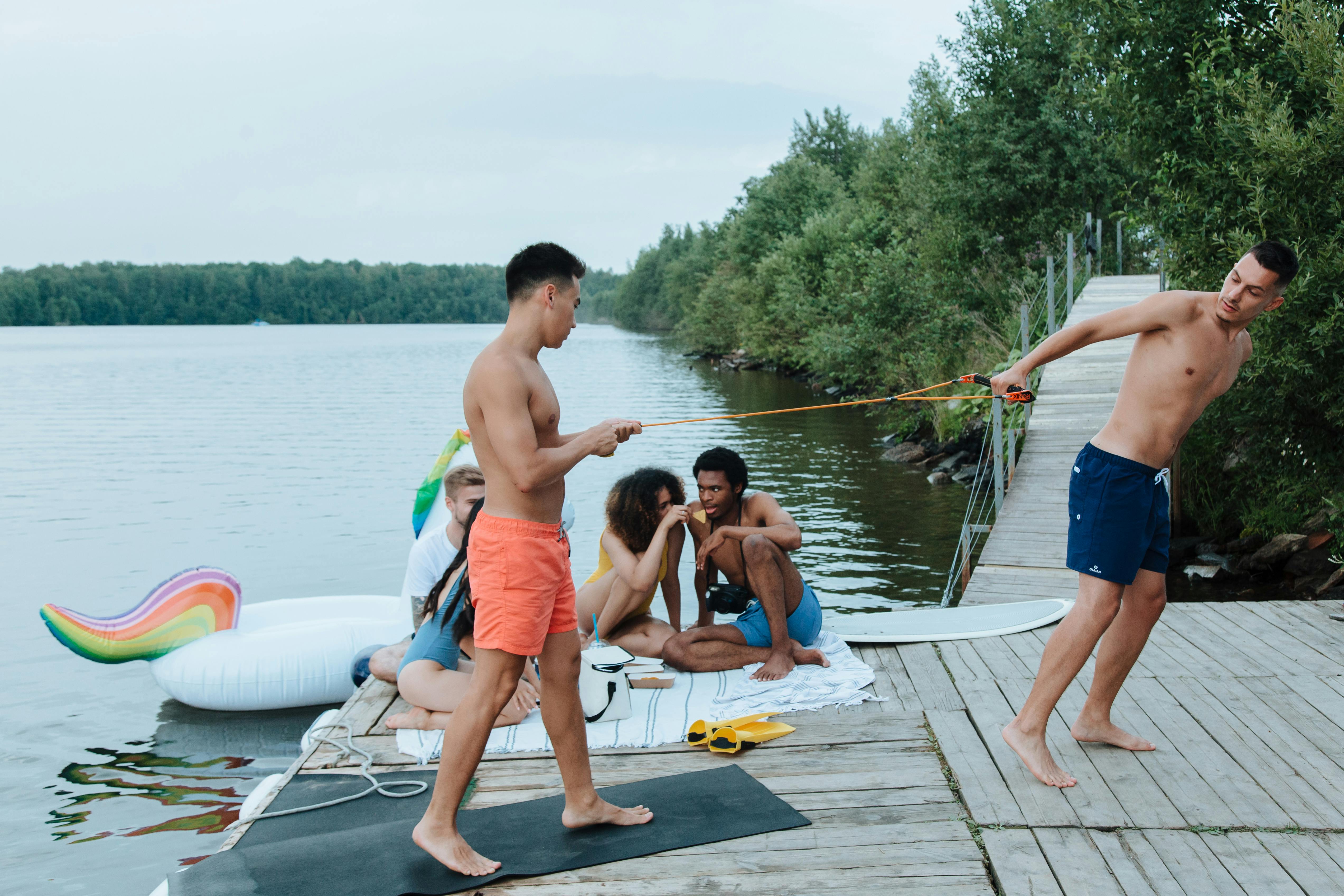 Group of Friends Having Fun on Pier on Lakeside · Free Stock Photo