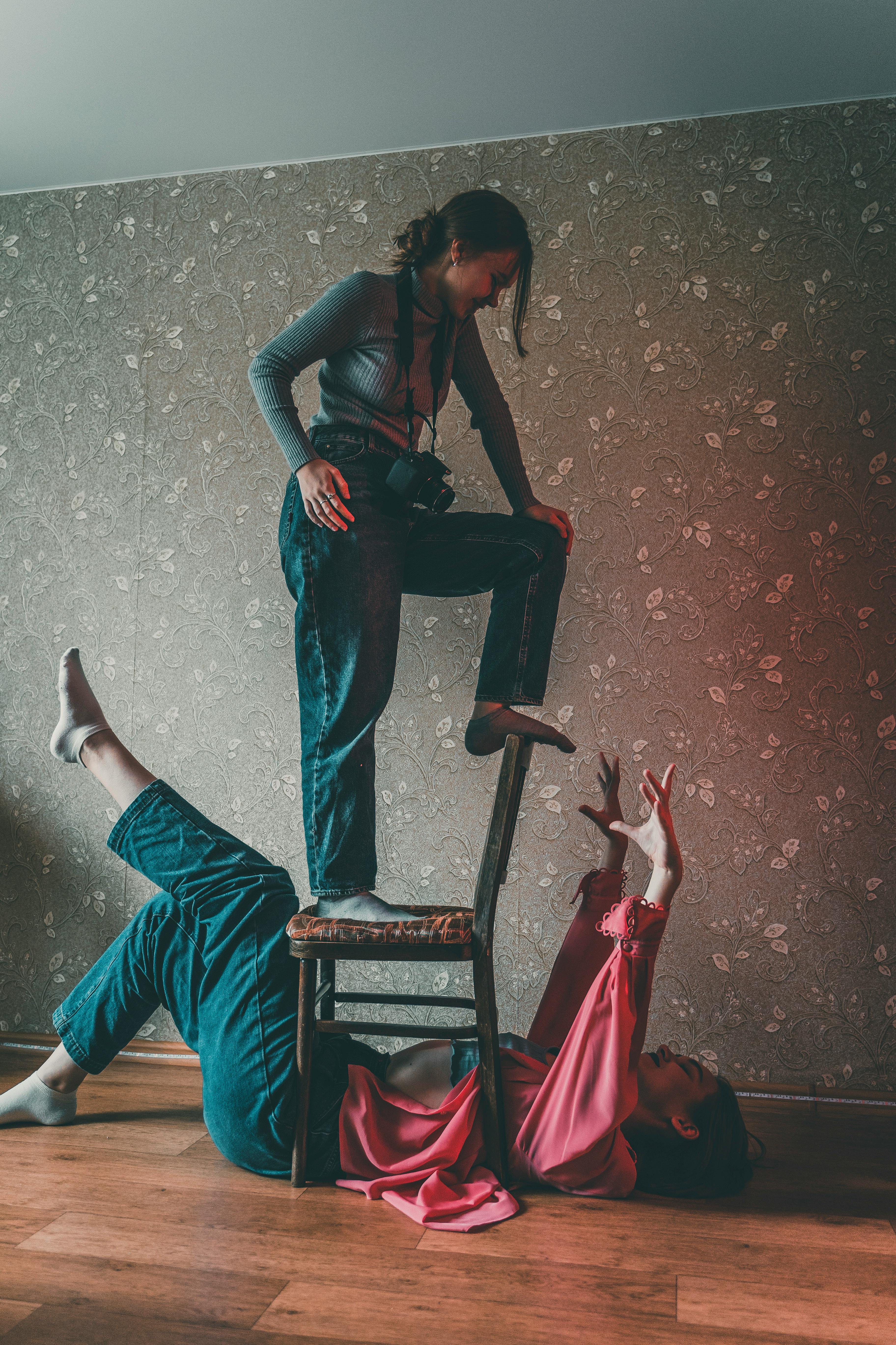 Woman Standing on Chair over Man · Free Stock Photo