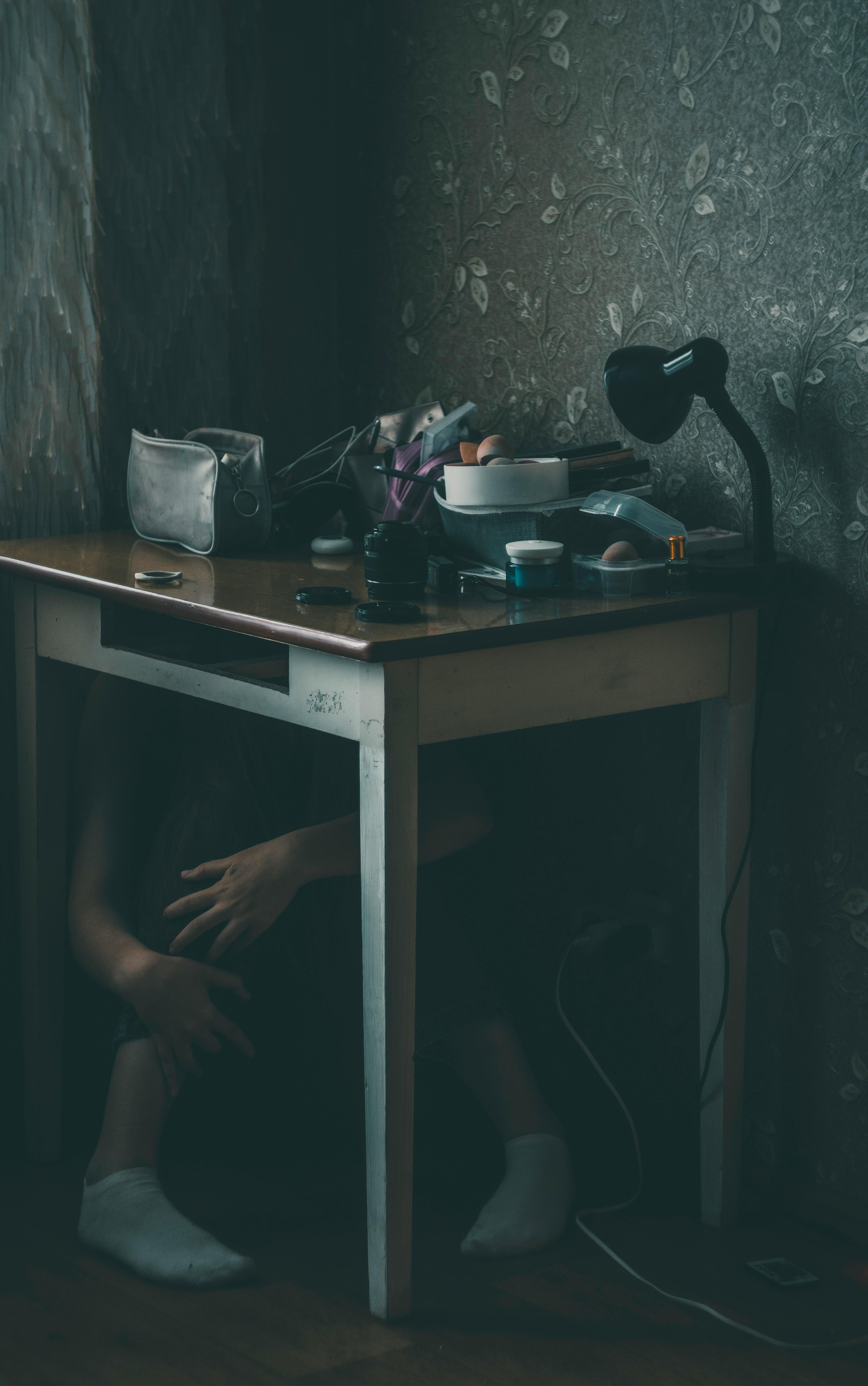 Person Sitting under Table · Free Stock Photo