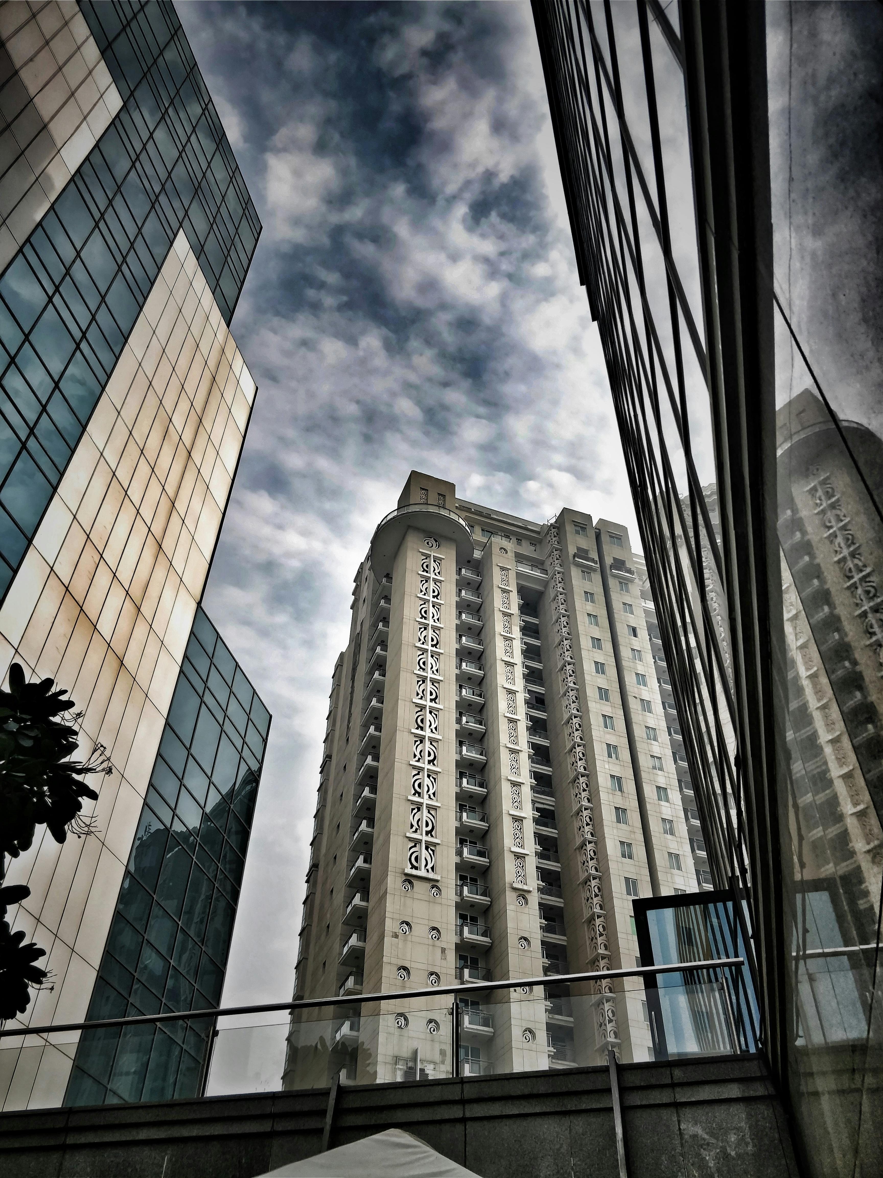 Low Angle View of Glass High Rise Building during Cloudy Daytime Photo ...