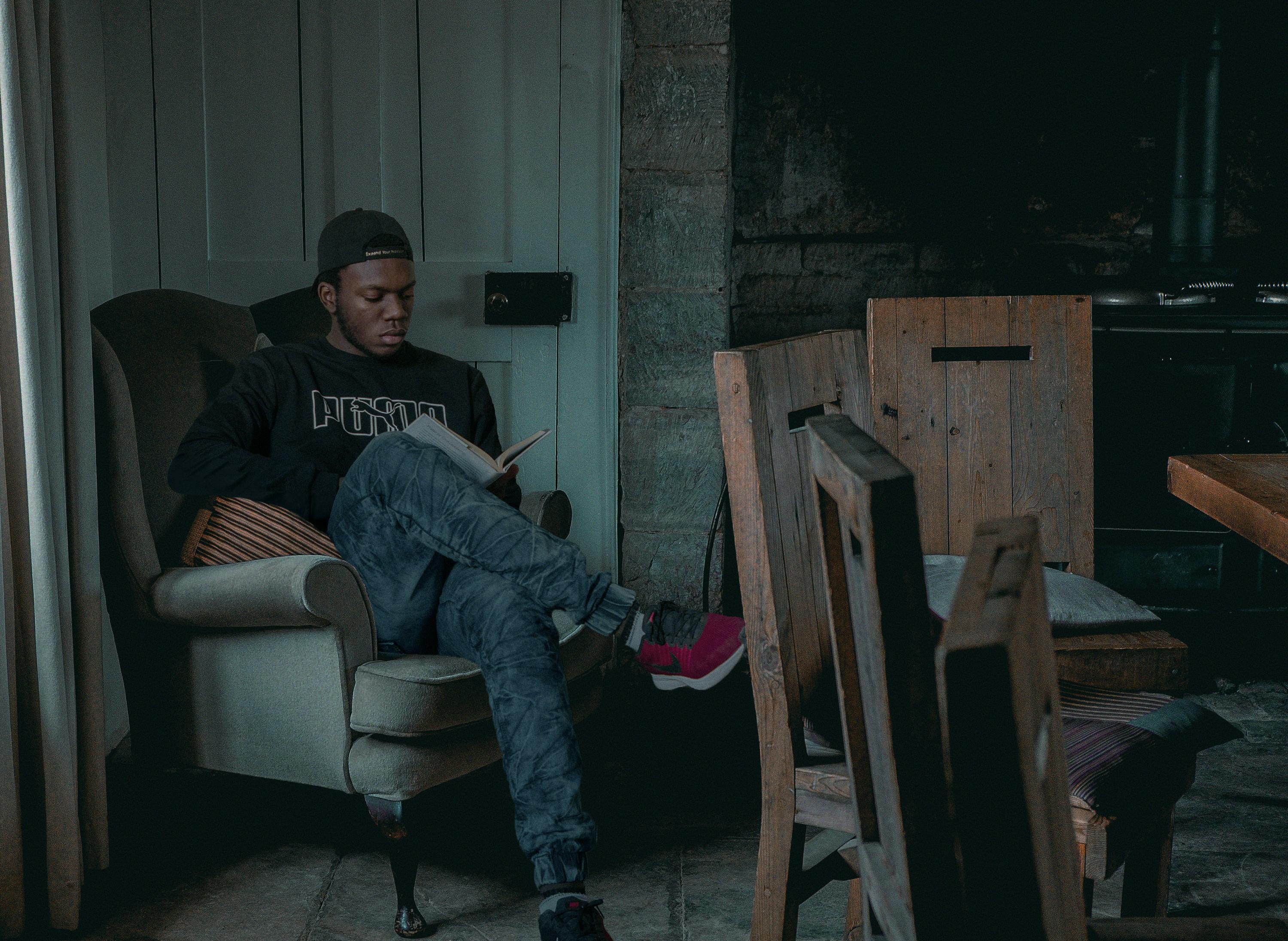 Man Reading a Book While Sitting on a Chair · Free Stock Photo