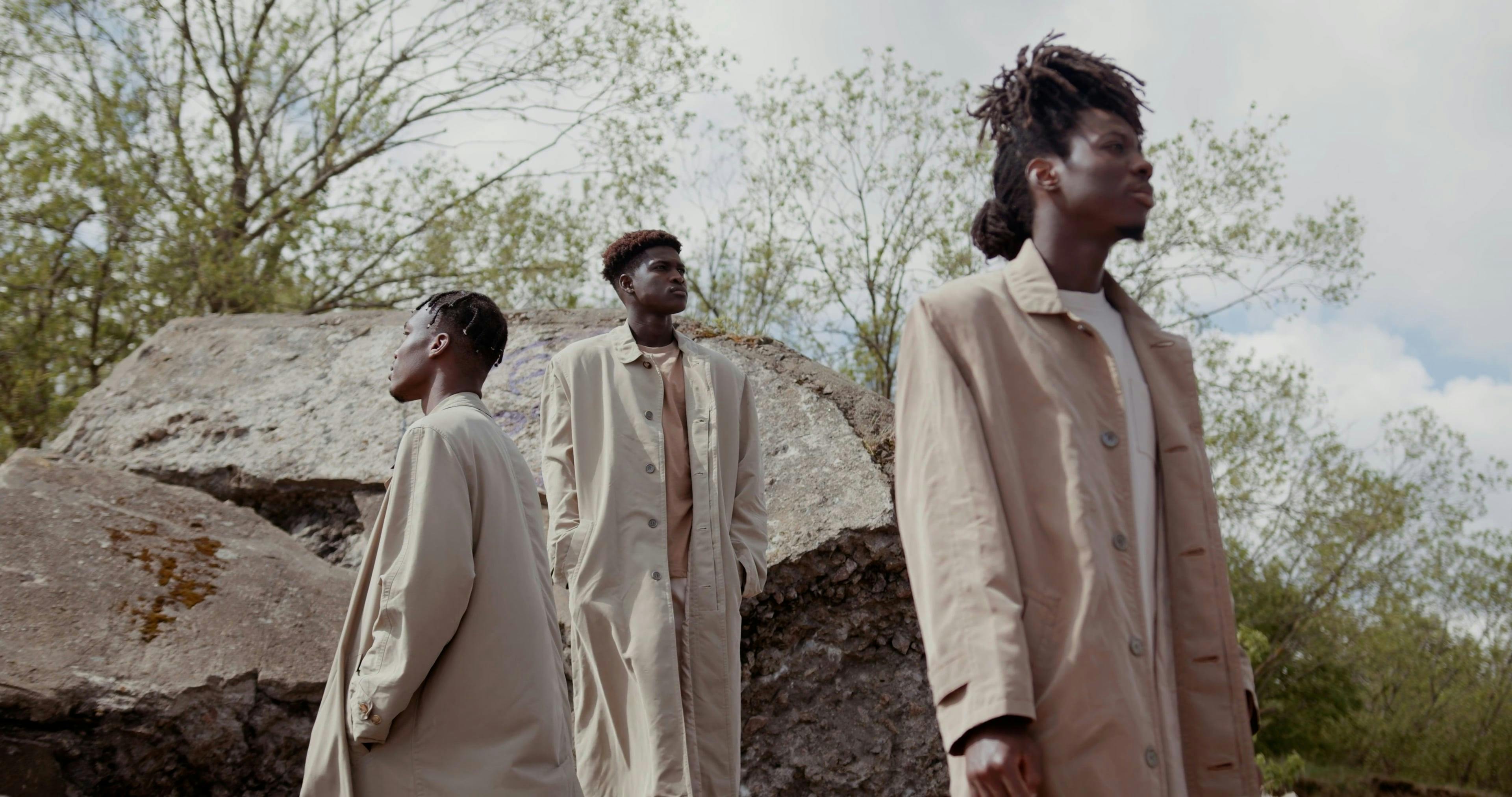 Men Wearing Trench Coats while Standing on a Cliff Rocks Free Stock ...