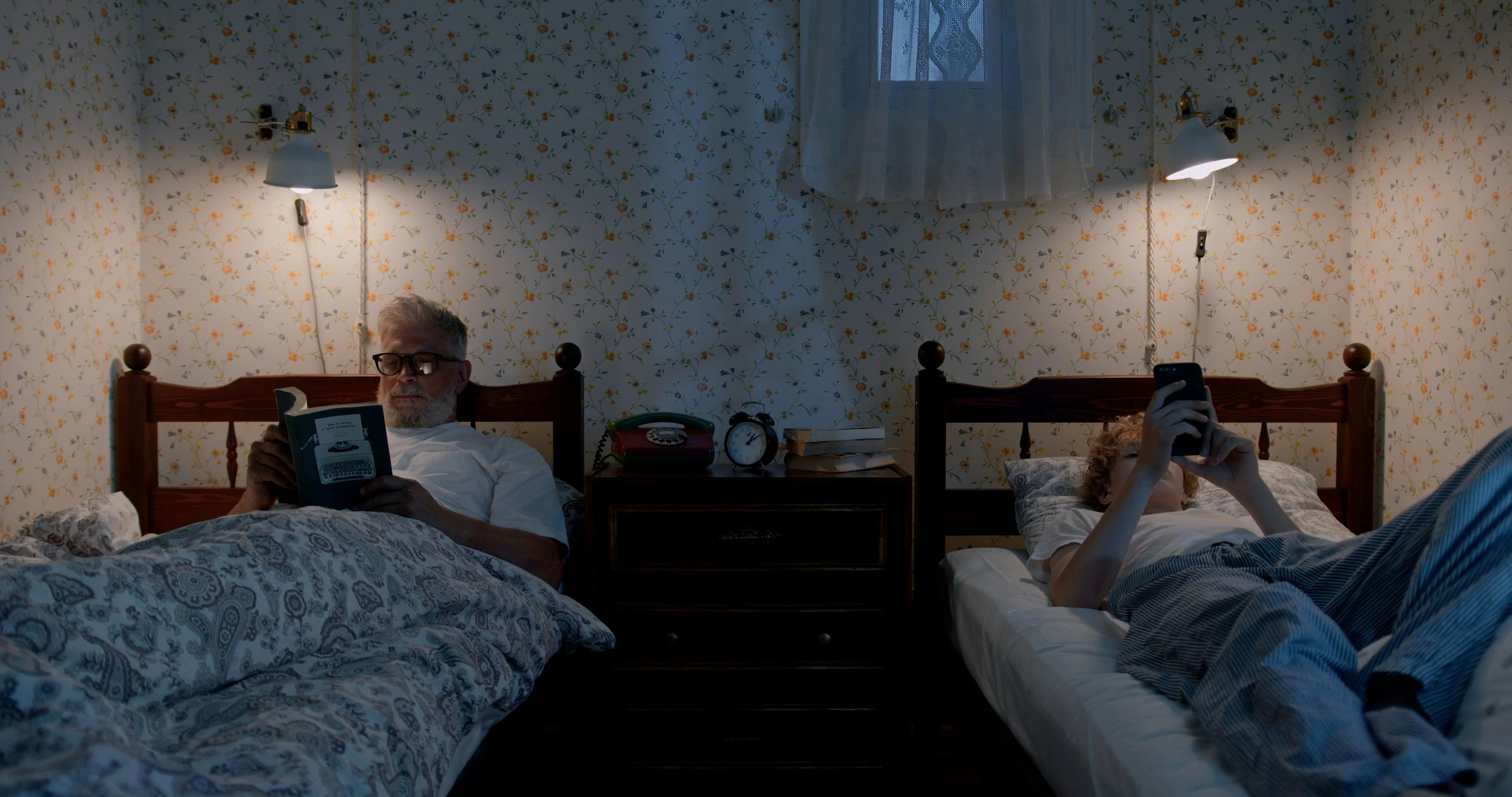 A Boy Getting Up from His Bed while Holding His Mobile Phone Free Stock ...