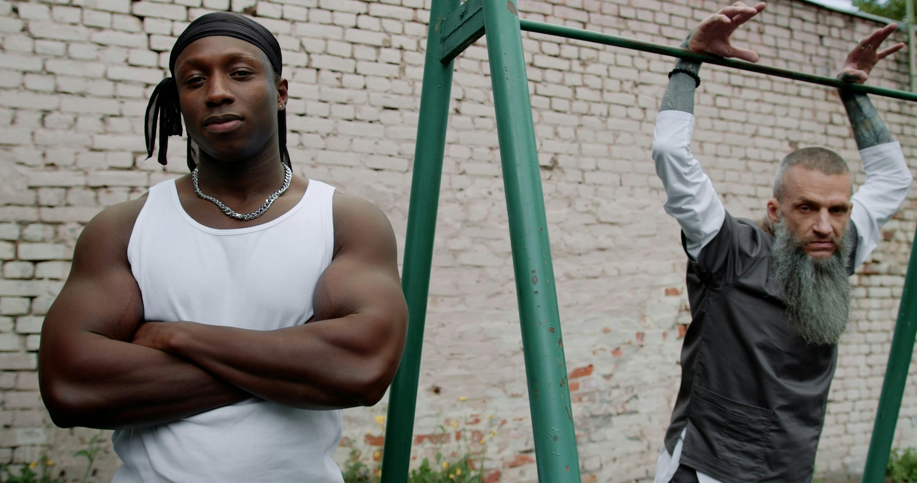 Two Men Posing by the Pull up Bar in the Prison Yard · Free Stock Video