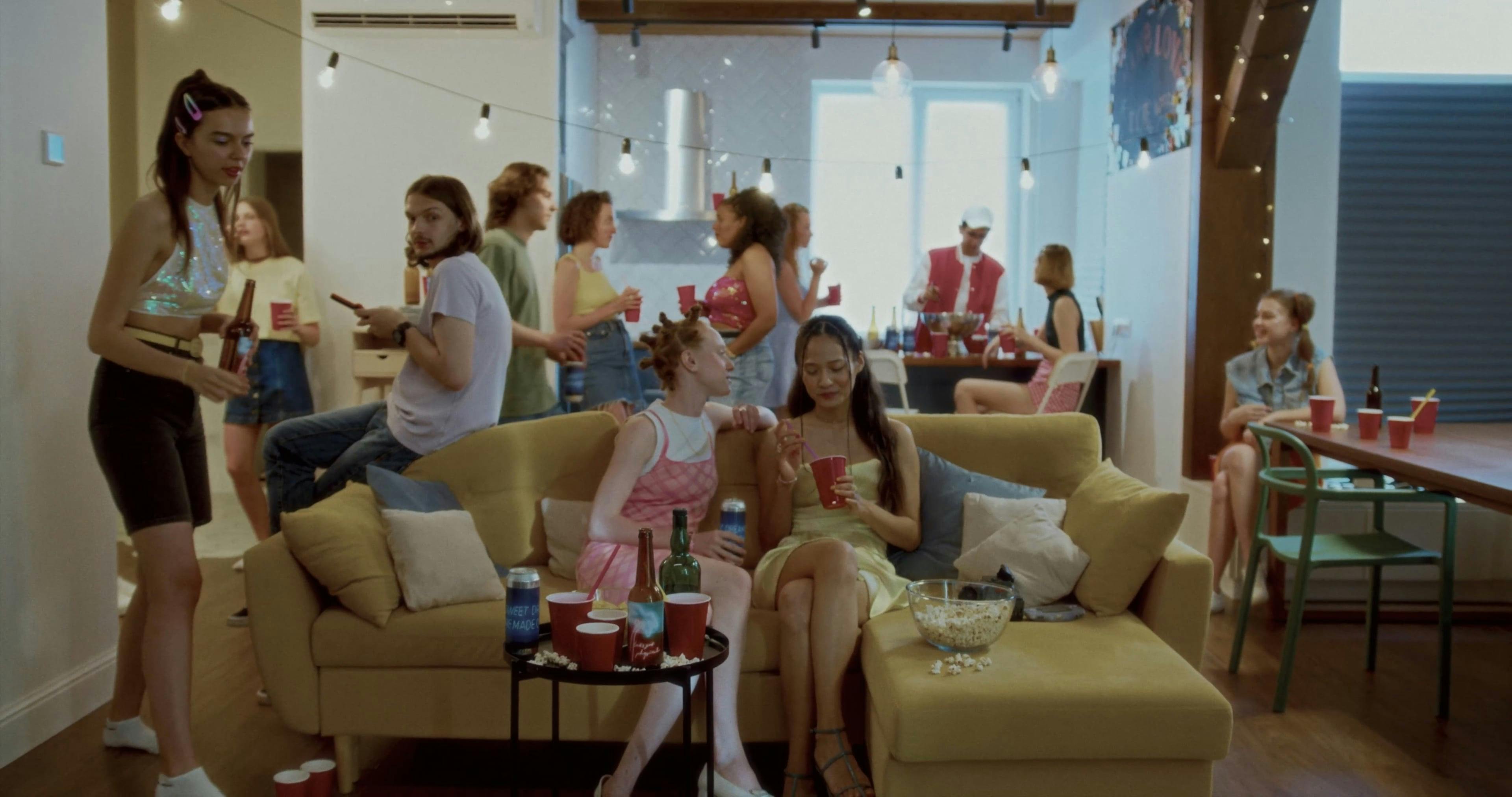 Two Young Women Sitting on a Sofa at a House Party Free Stock Video ...