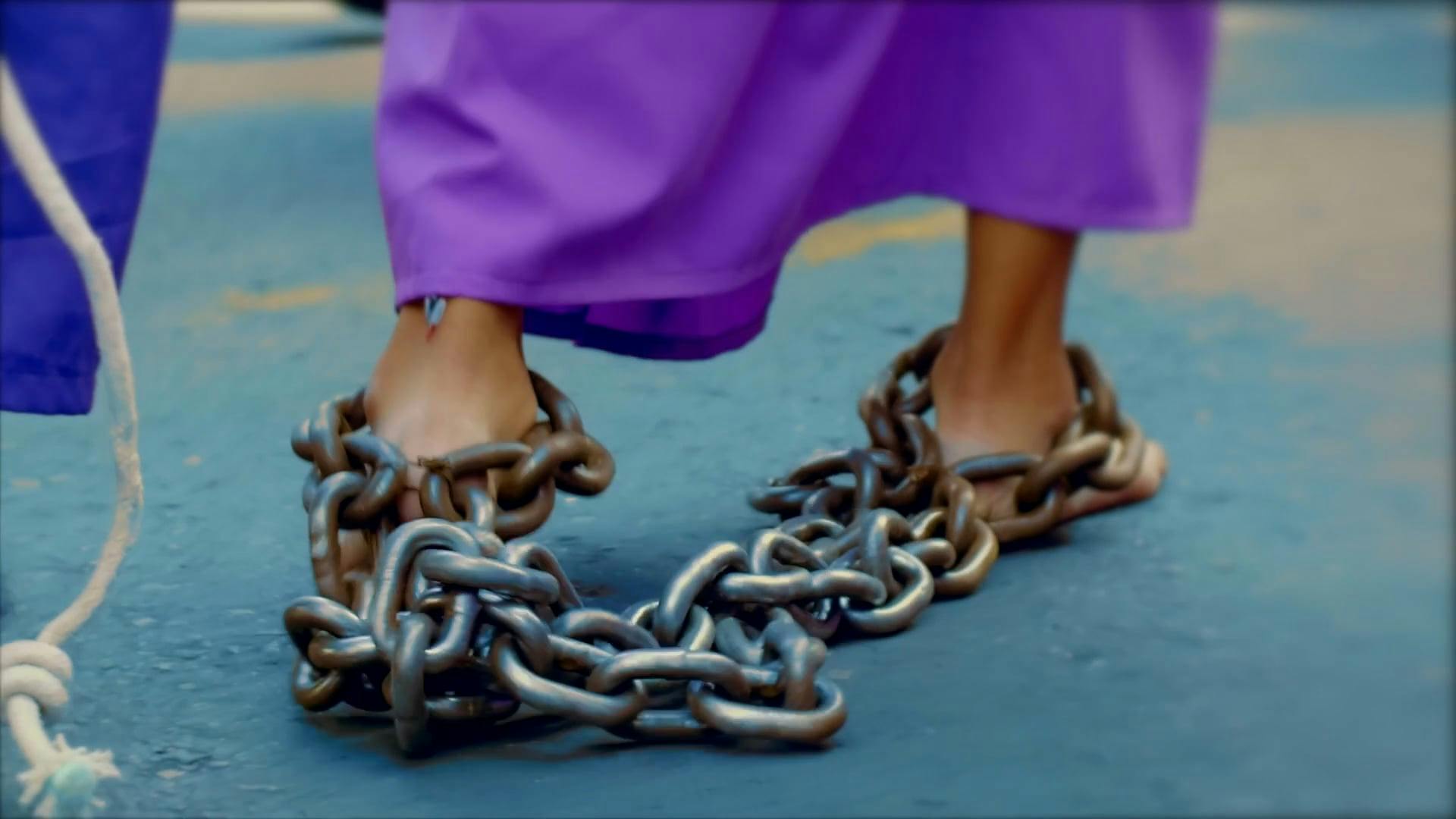 A Person Walking with Chains on their Feet during a Procession Free ...