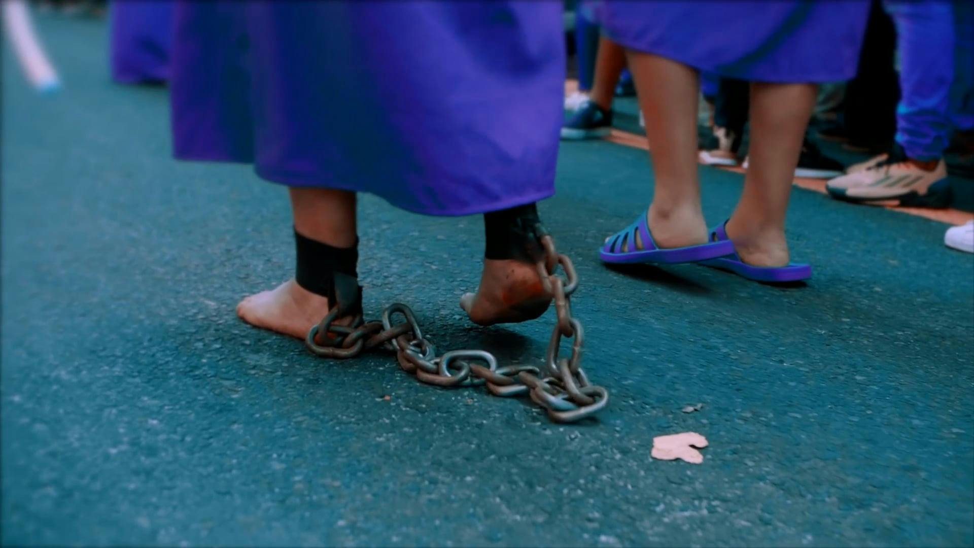 A Penitent with Chained Feet Walking during a Procession Free Stock ...