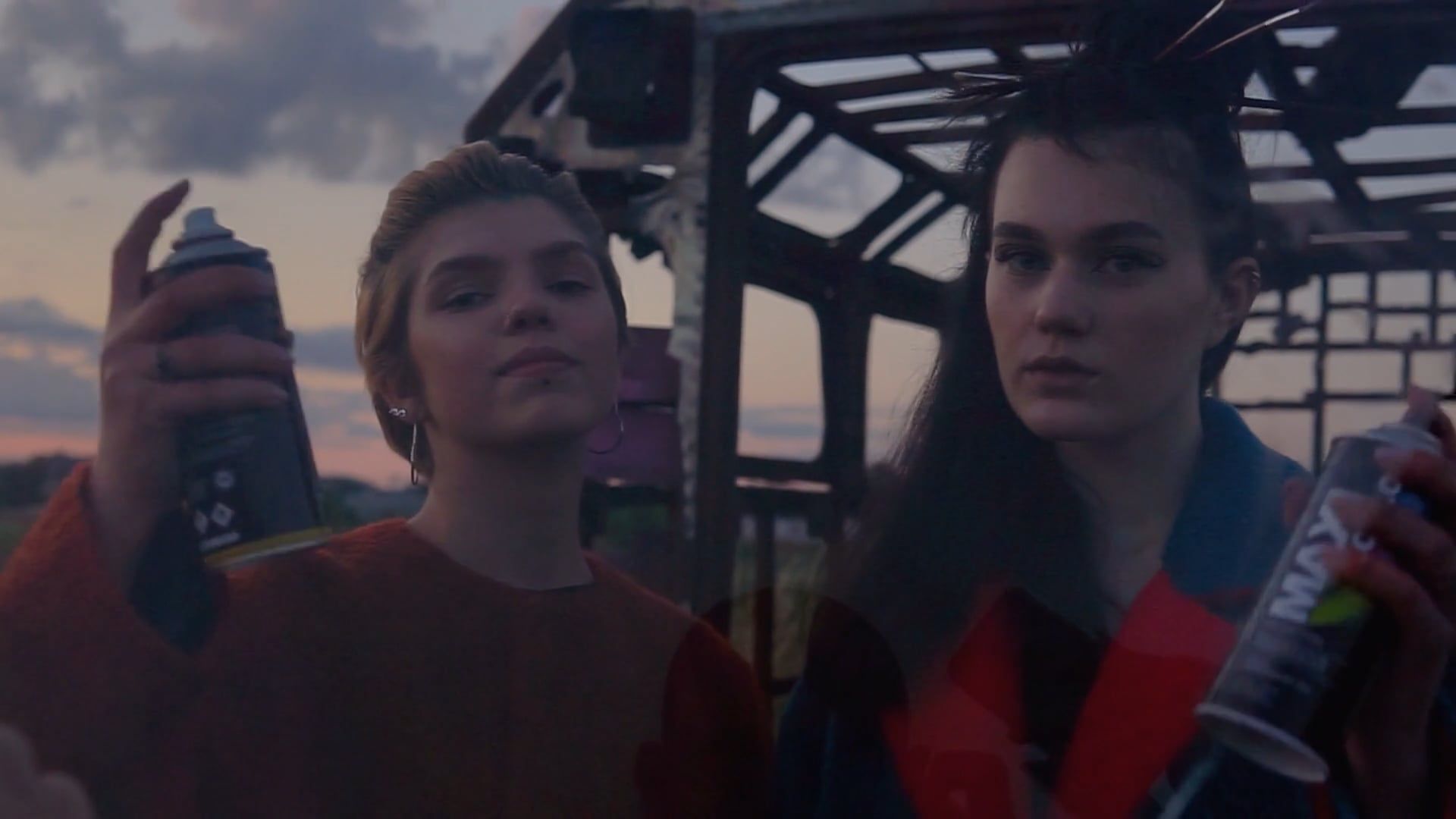 Two Women Using Spray Paint on a Glass while Pointing at the Camera ...