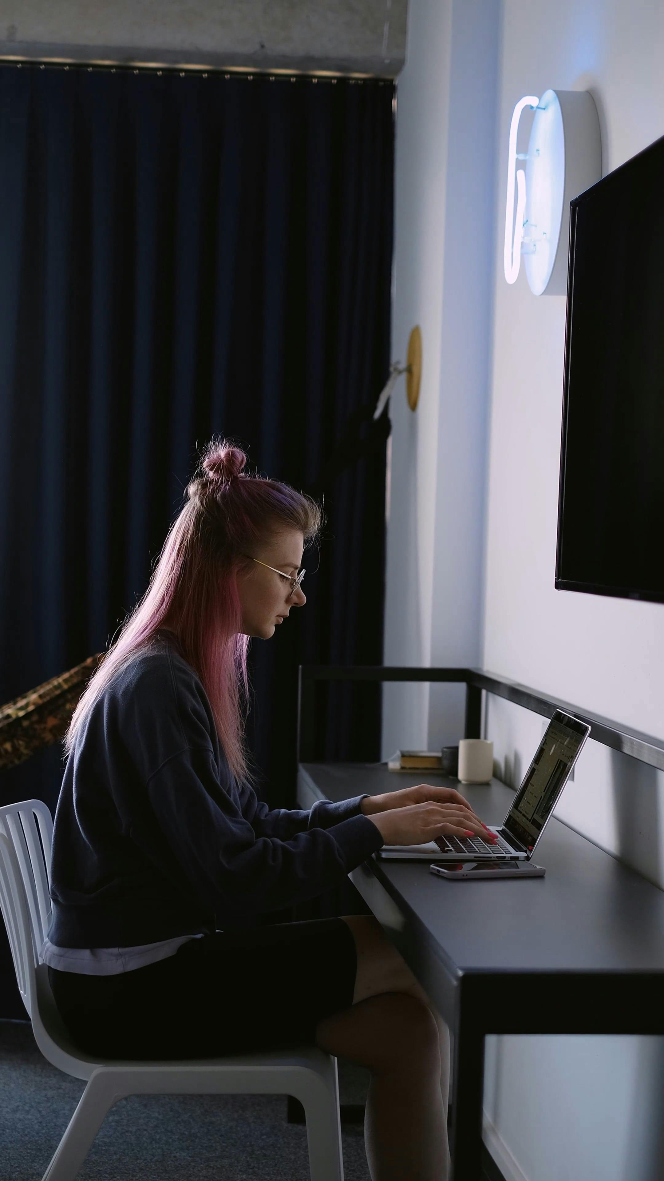 A Young Woman Sitting on a Chair Using a Laptop Computer Free Stock ...