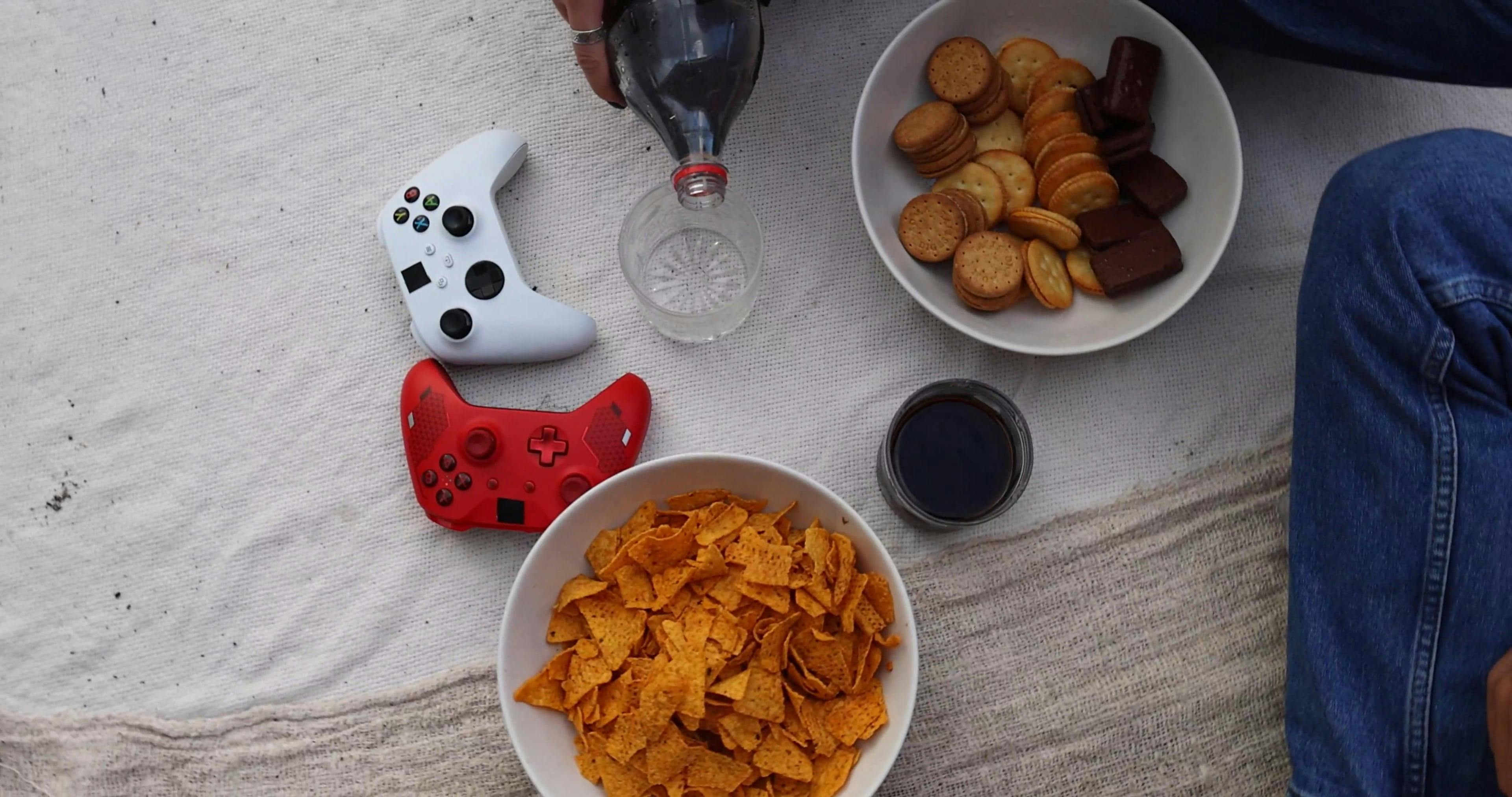 Snacks and Soft Drink Glasses next to Wireless Game Controllers Free ...
