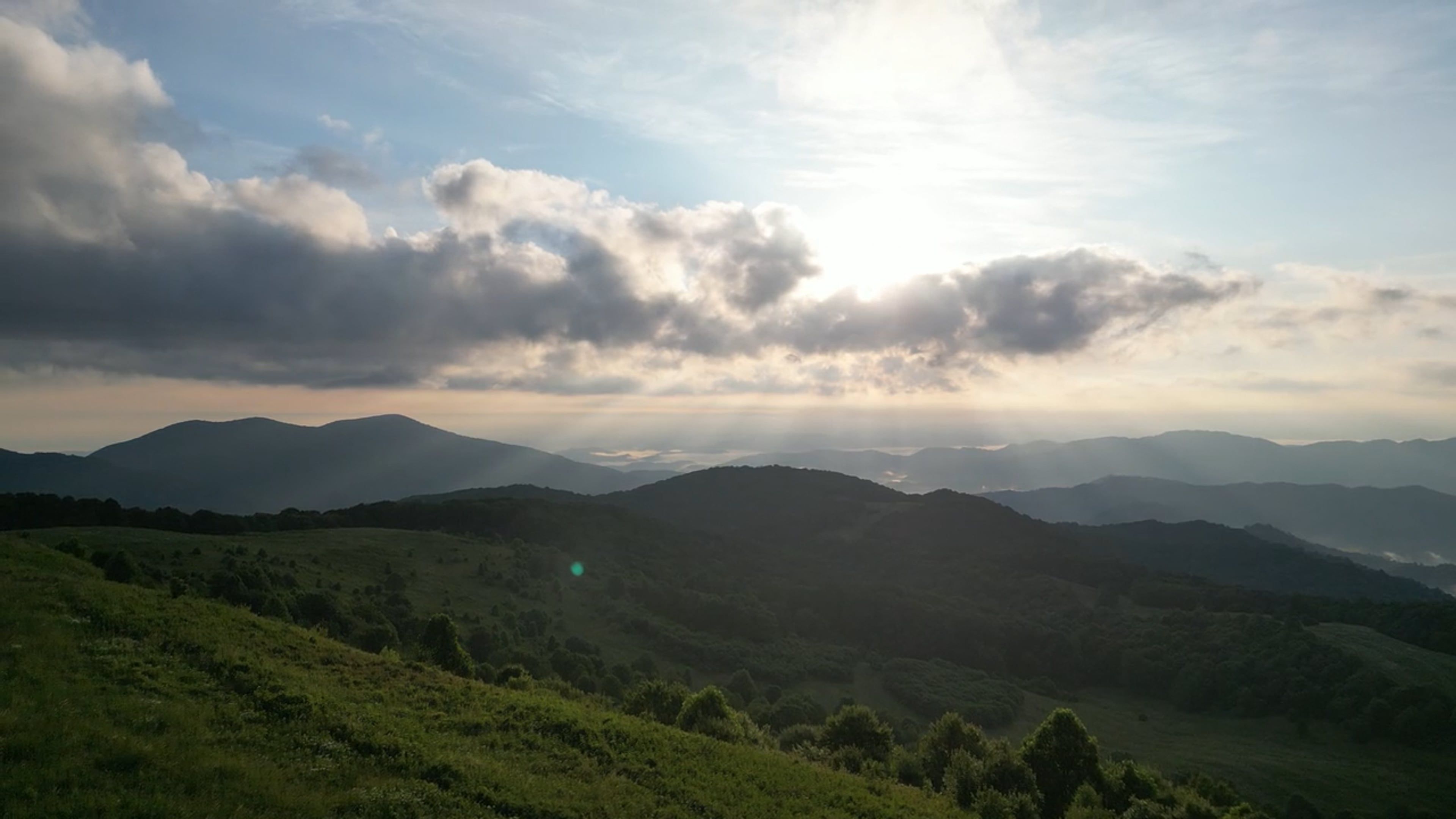 The Sun Shining through the Clouds over a Mountain Landscape Free Stock ...