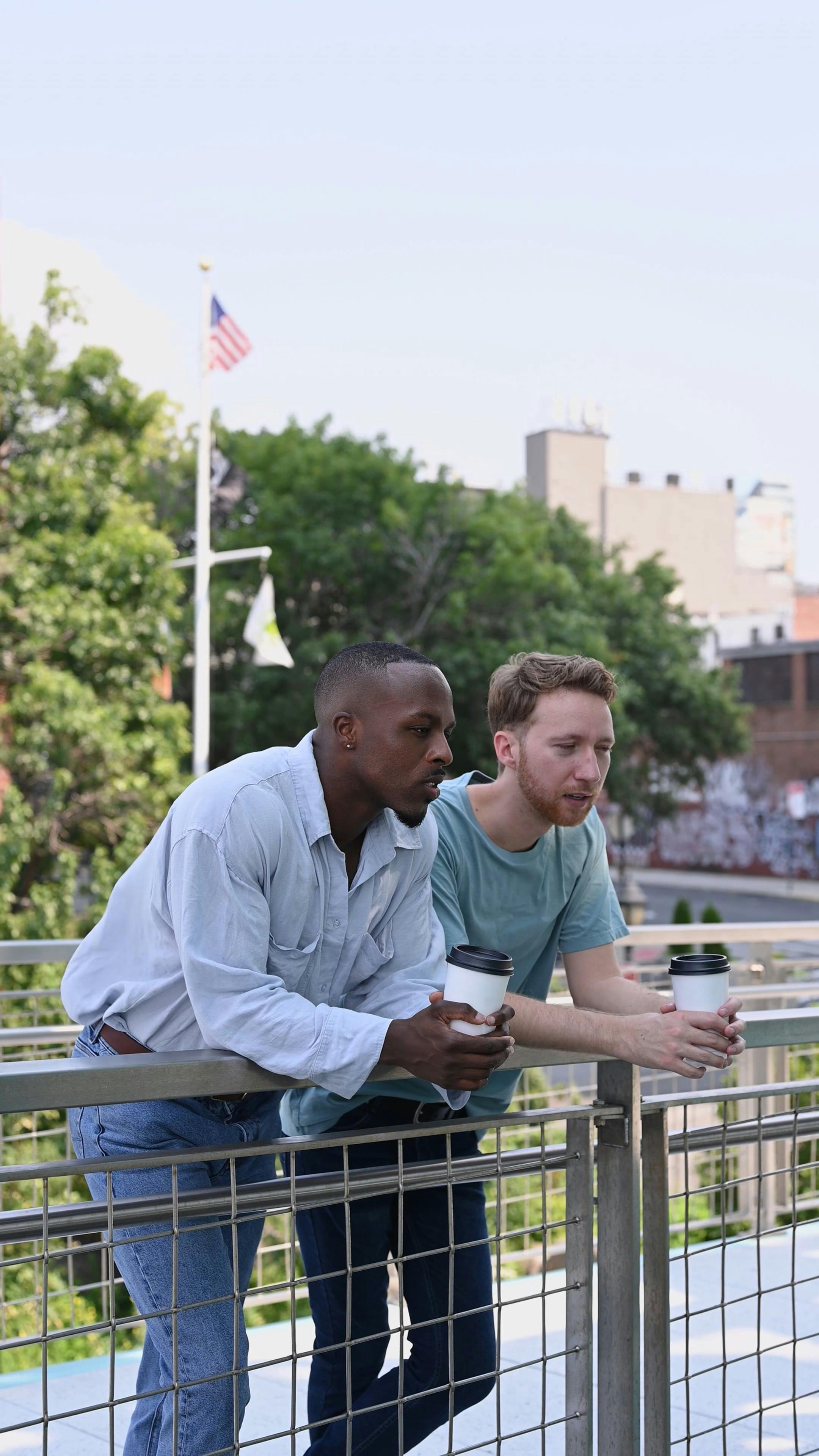 Two Men Talking while Leaning on a Pedestrian Bridge Railing Free Stock ...
