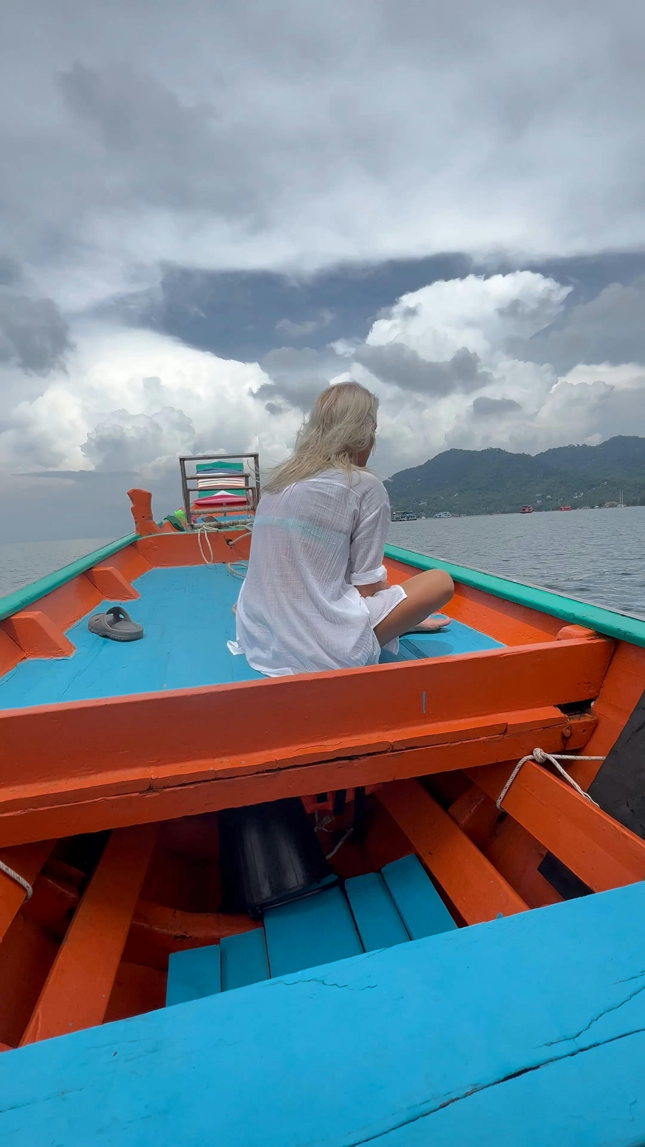 A Woman Sitting on the Deck of a Colorful Motorboat Free Stock Video ...