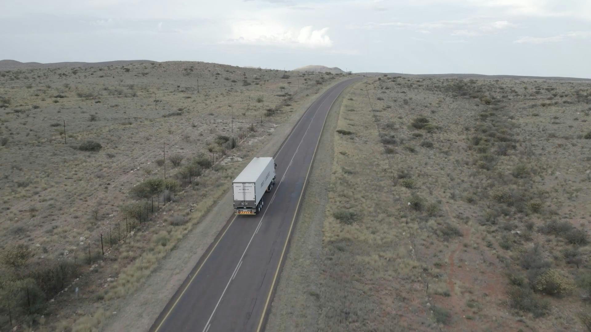 A Wide Shot Of Truck Driving Down A Desert Road Videos, Download The ...
