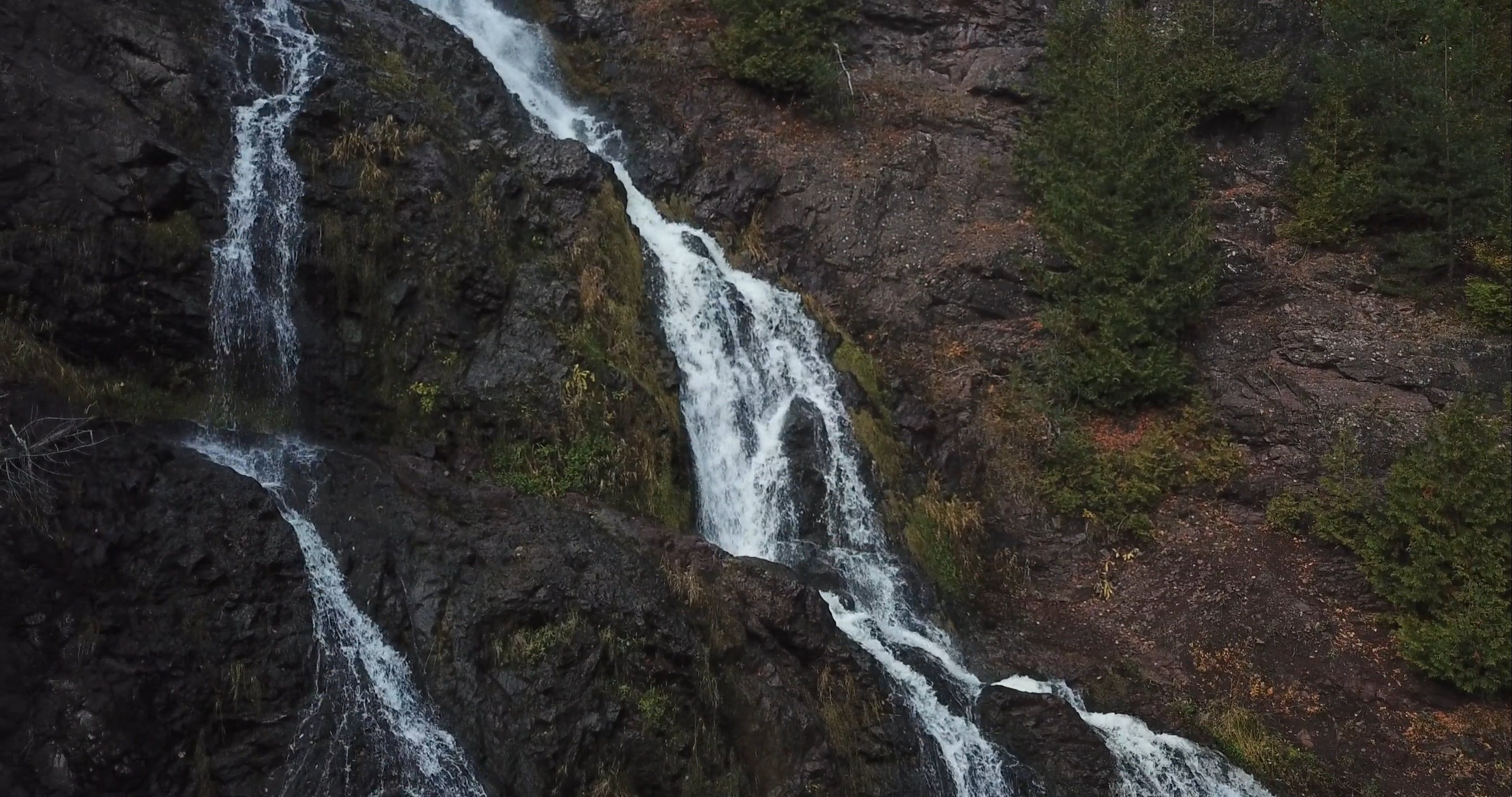 A Drone Footage of a Waterfalls Between Rock Formations Free Stock ...