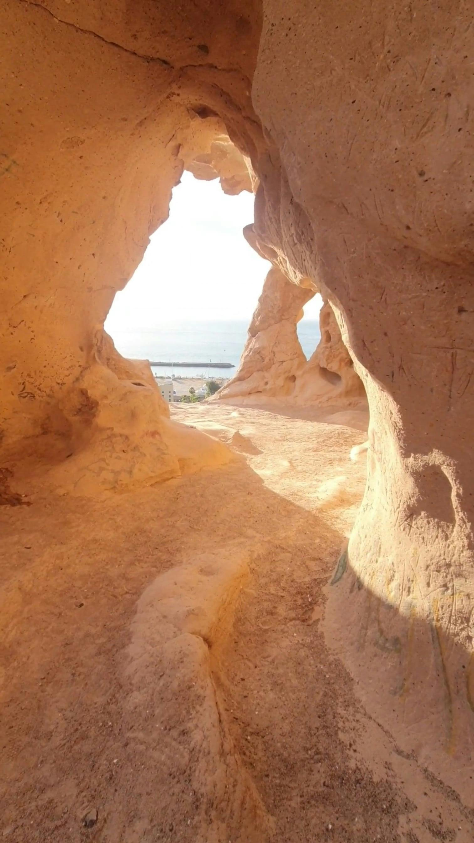 The sun is shining through the rocks at the top of a cliff Free Stock ...