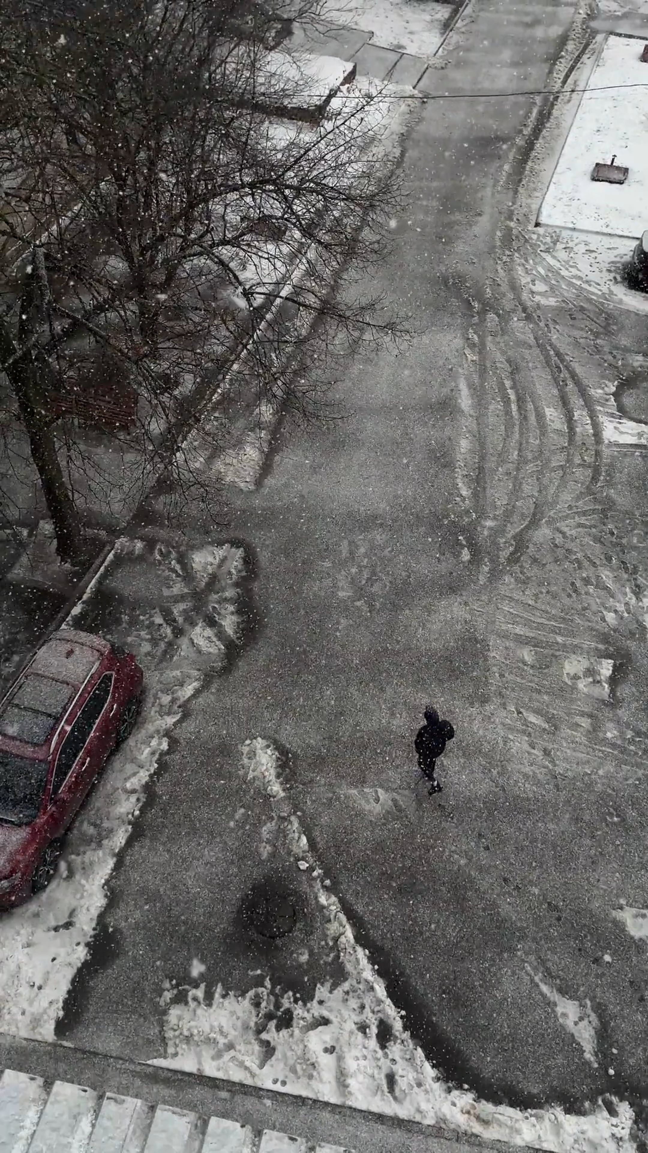 High Angle View of a Person Crossing the Street on a Snowy Winter Day ...
