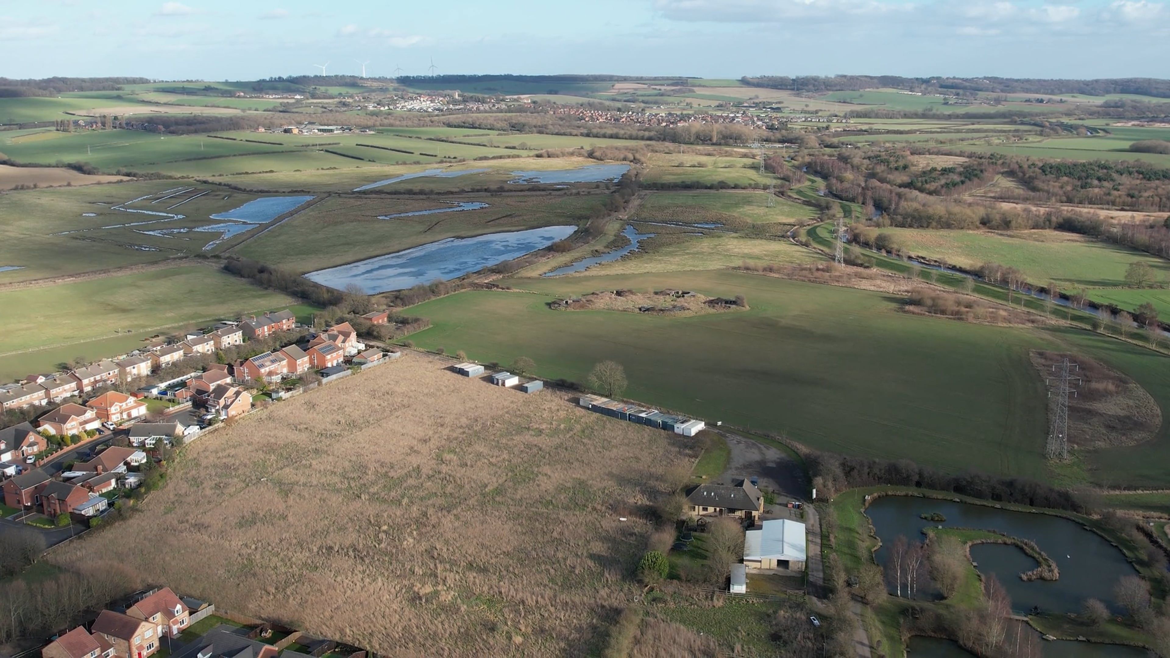 An aerial view of a field with houses and a river Free Stock Video ...