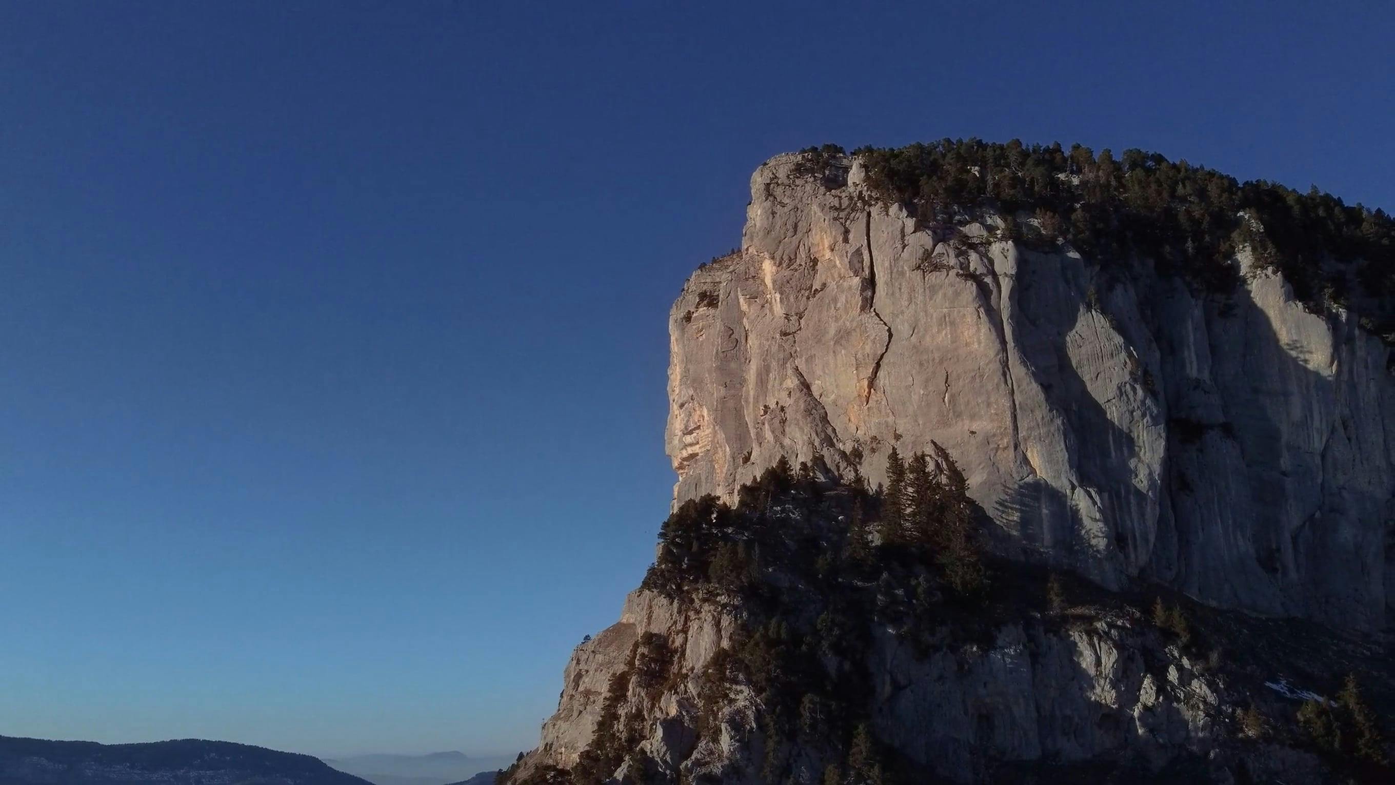 Drone footage of a huge moutain with nice sun color and close to a ...