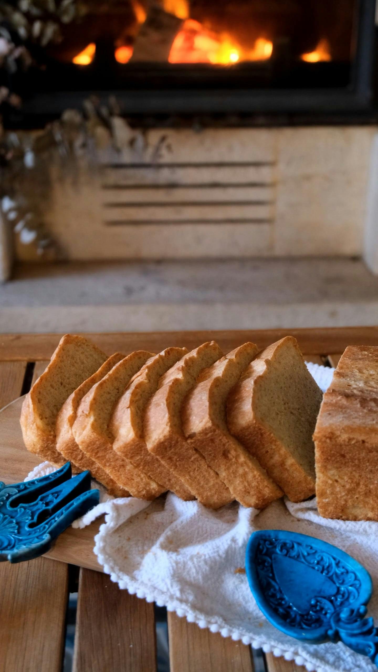 A loaf of bread sitting on a cutting board next to a fireplace Free ...